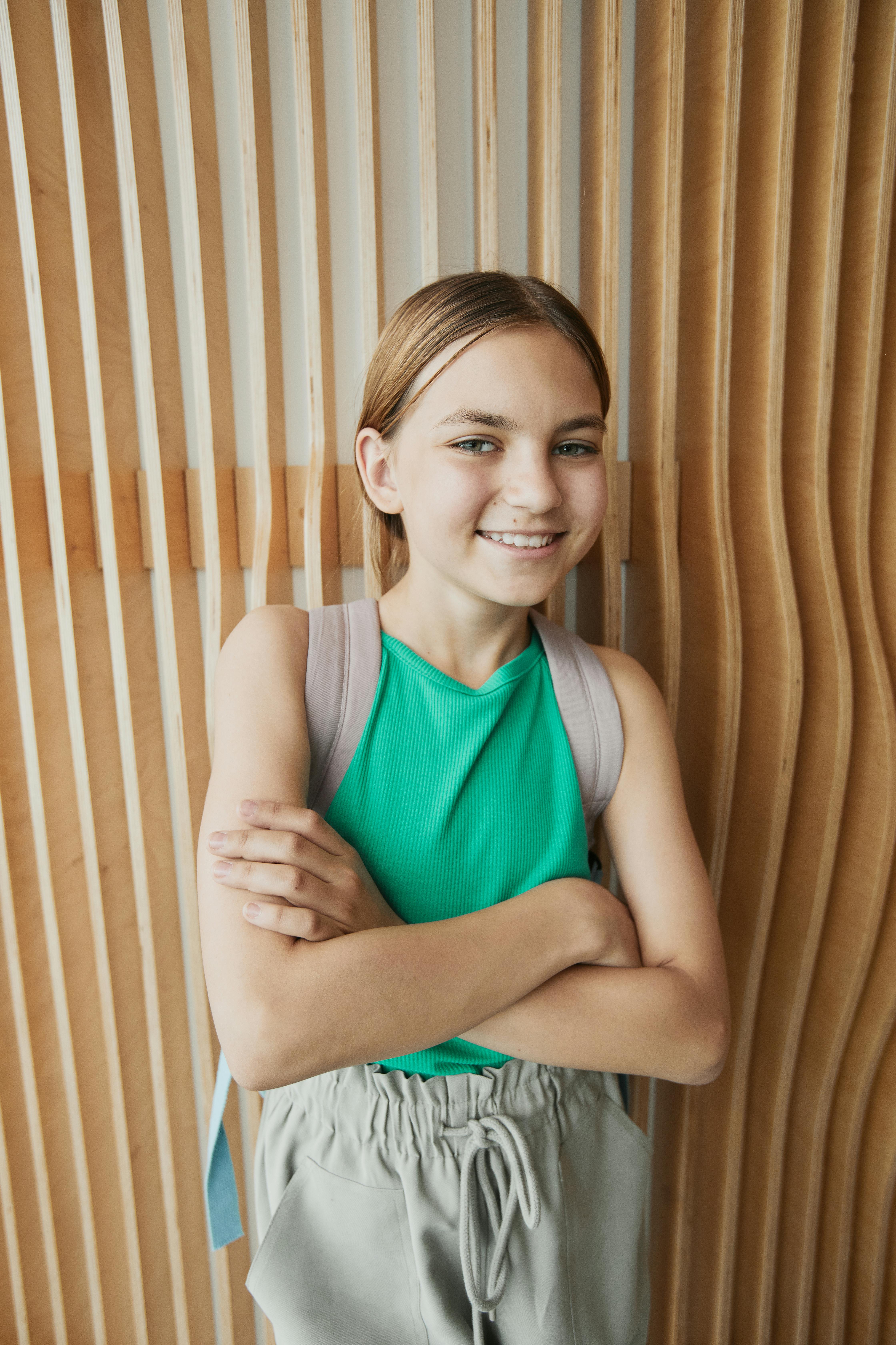 Pretty Girl in Green Tank Top Leaning on a Wooden Wall · Free Stock Photo