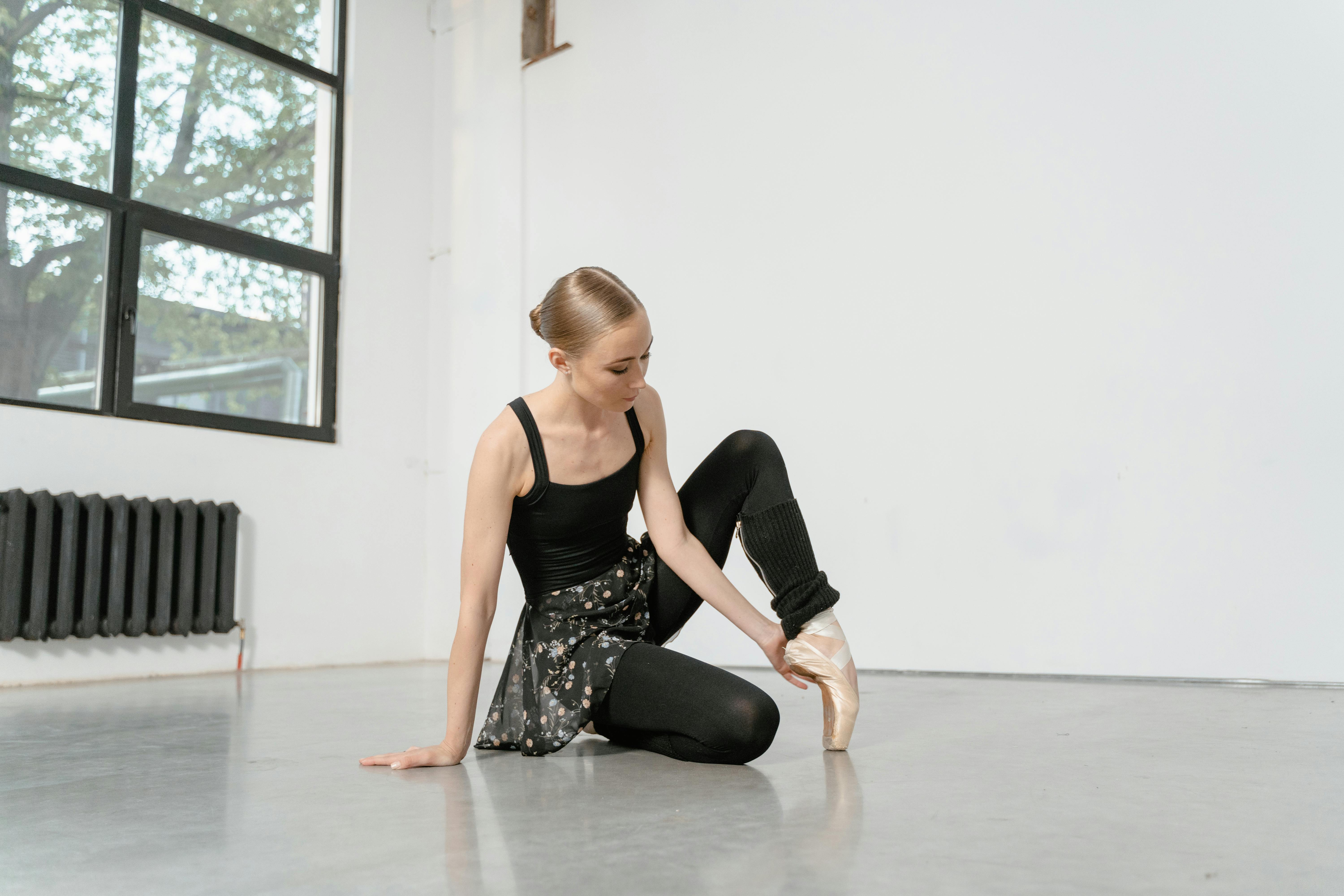 A Ballerina Checking the Pointe Shoe she is Wearing · Free Stock Photo