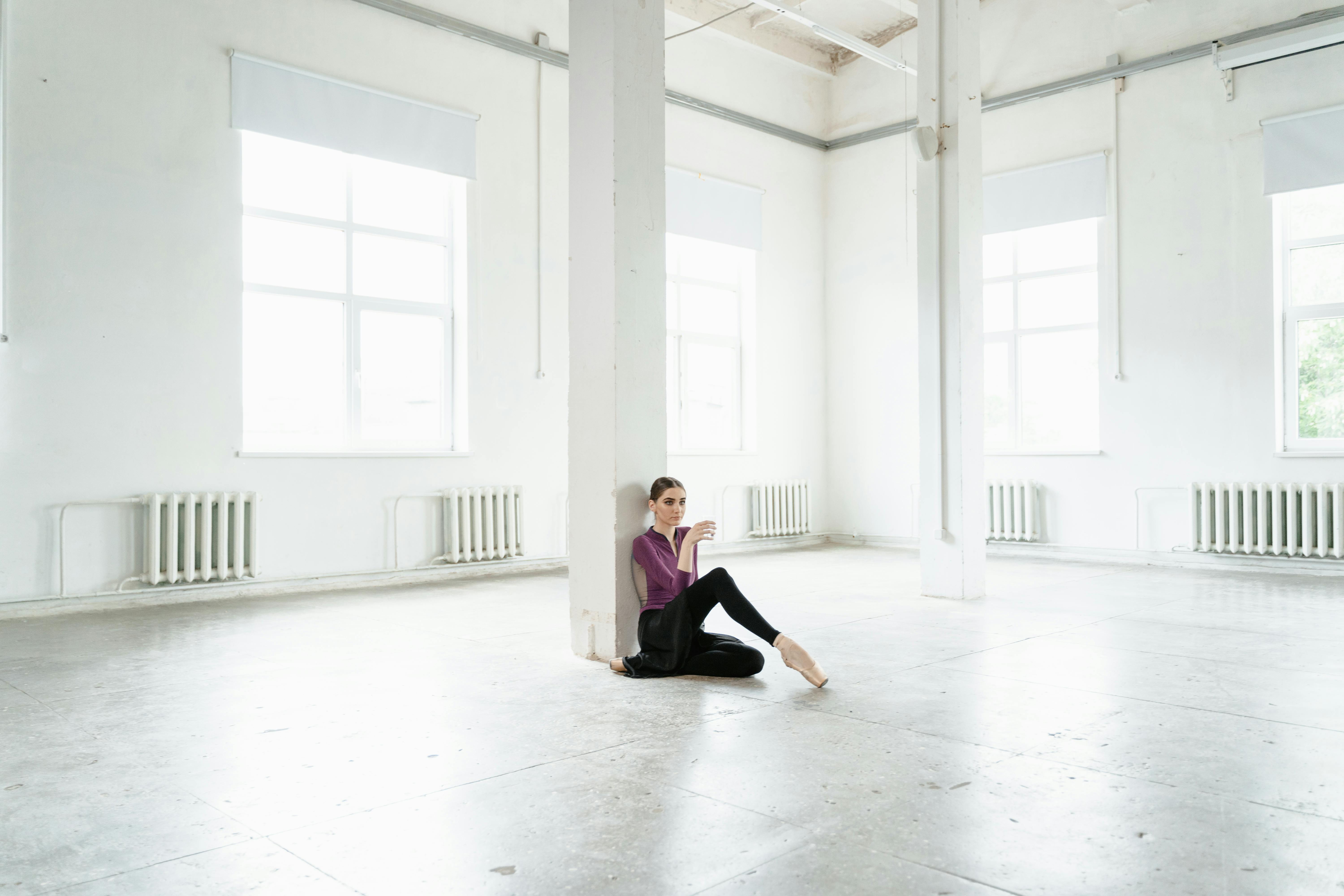 A Ballerina Resting While Leaning on a Pillar · Free Stock Photo