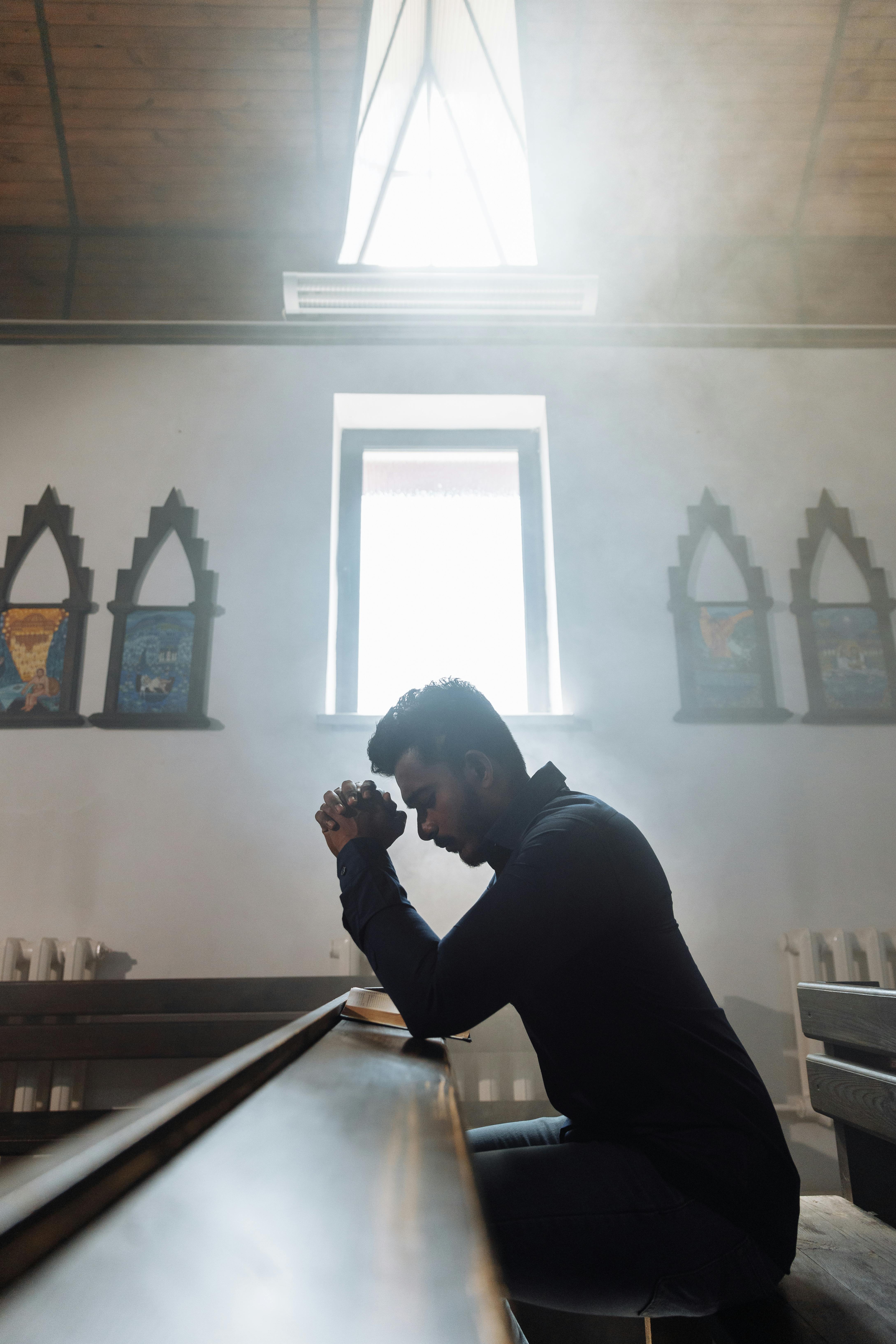 Man in Black Long Sleeves Praying inside the Church · Free Stock Photo
