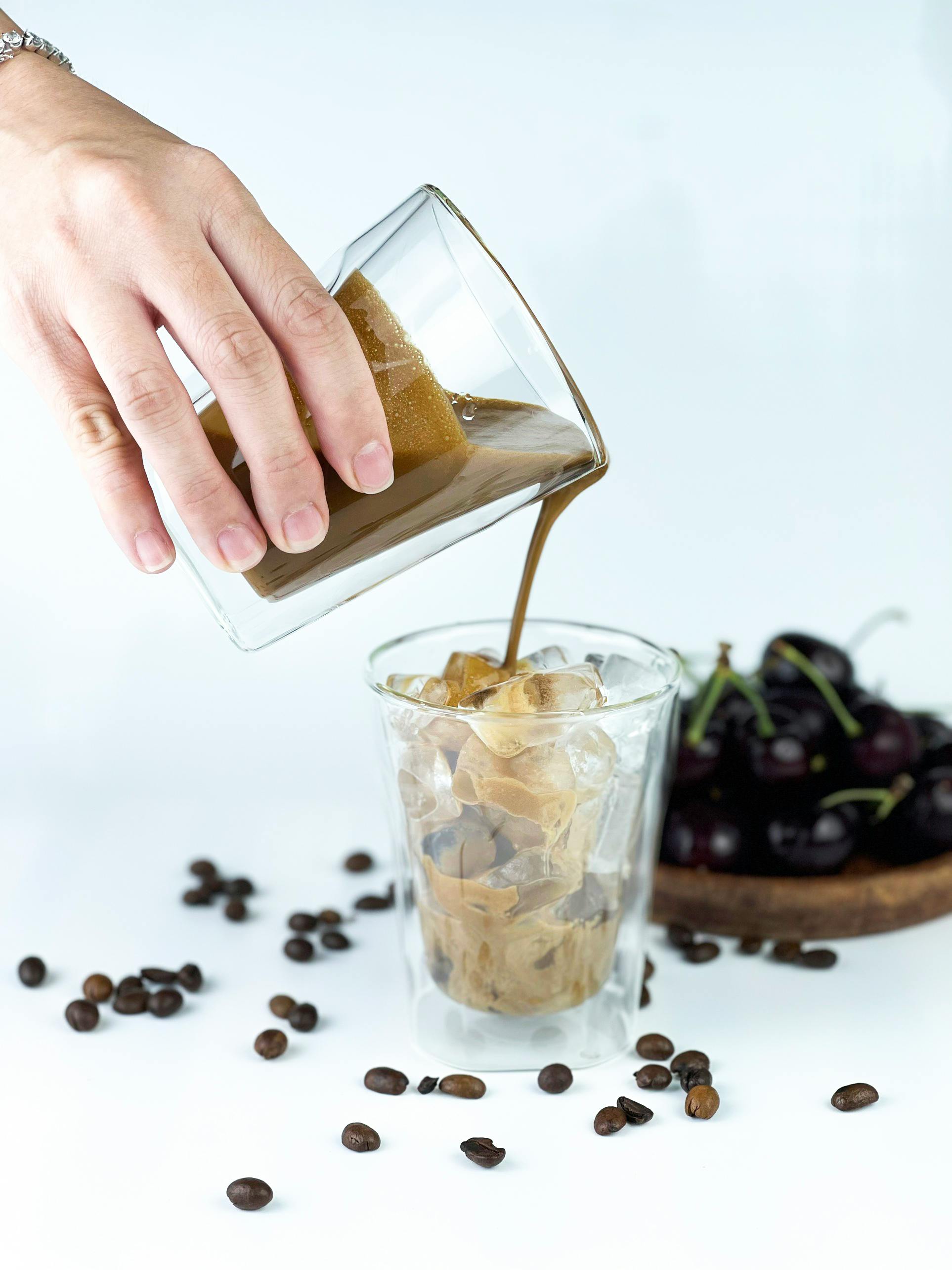 Person Pouring Brown Liquid on Clear Drinking Glass · Free Stock Photo