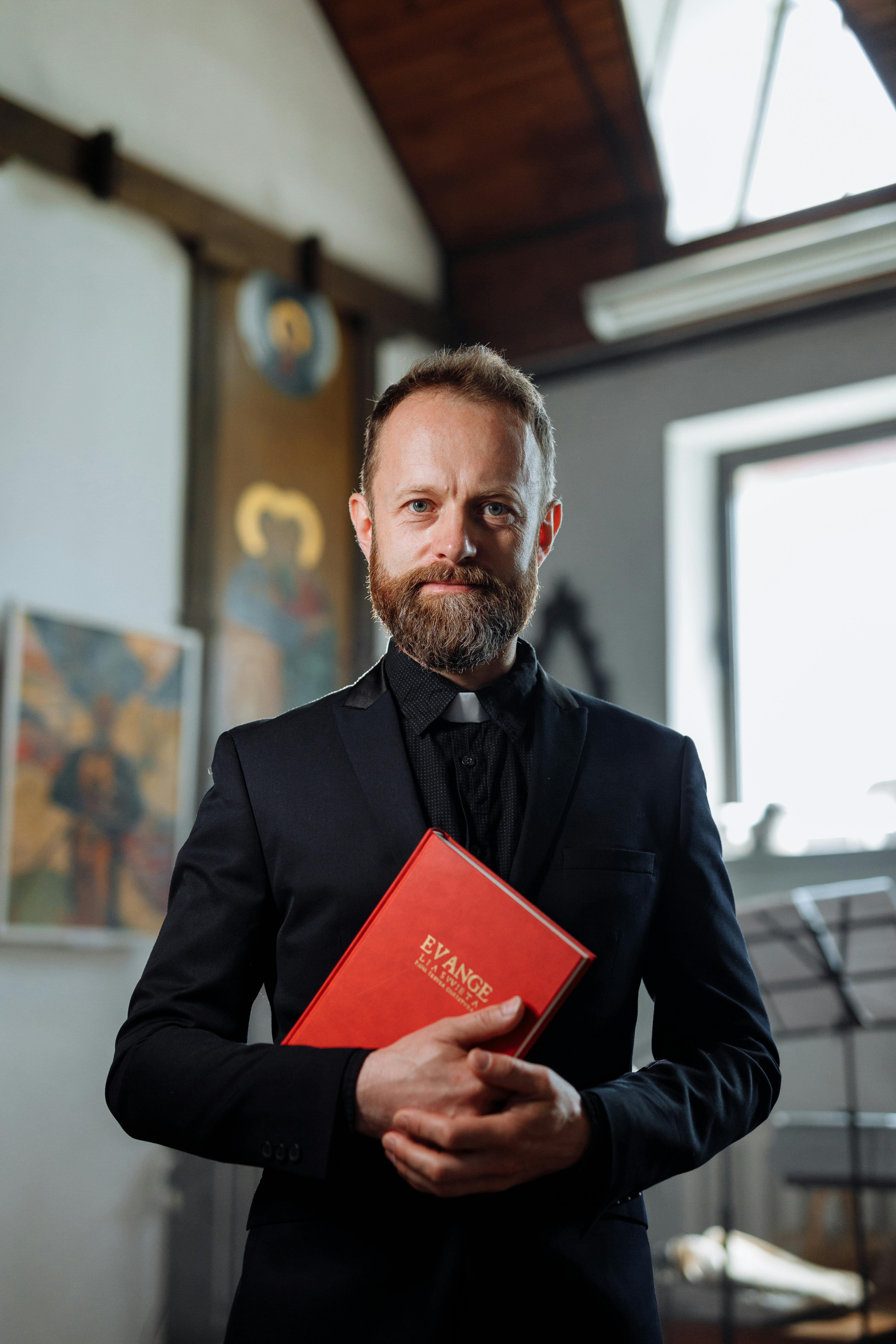 Man in Black Suit Holding Red Book · Free Stock Photo