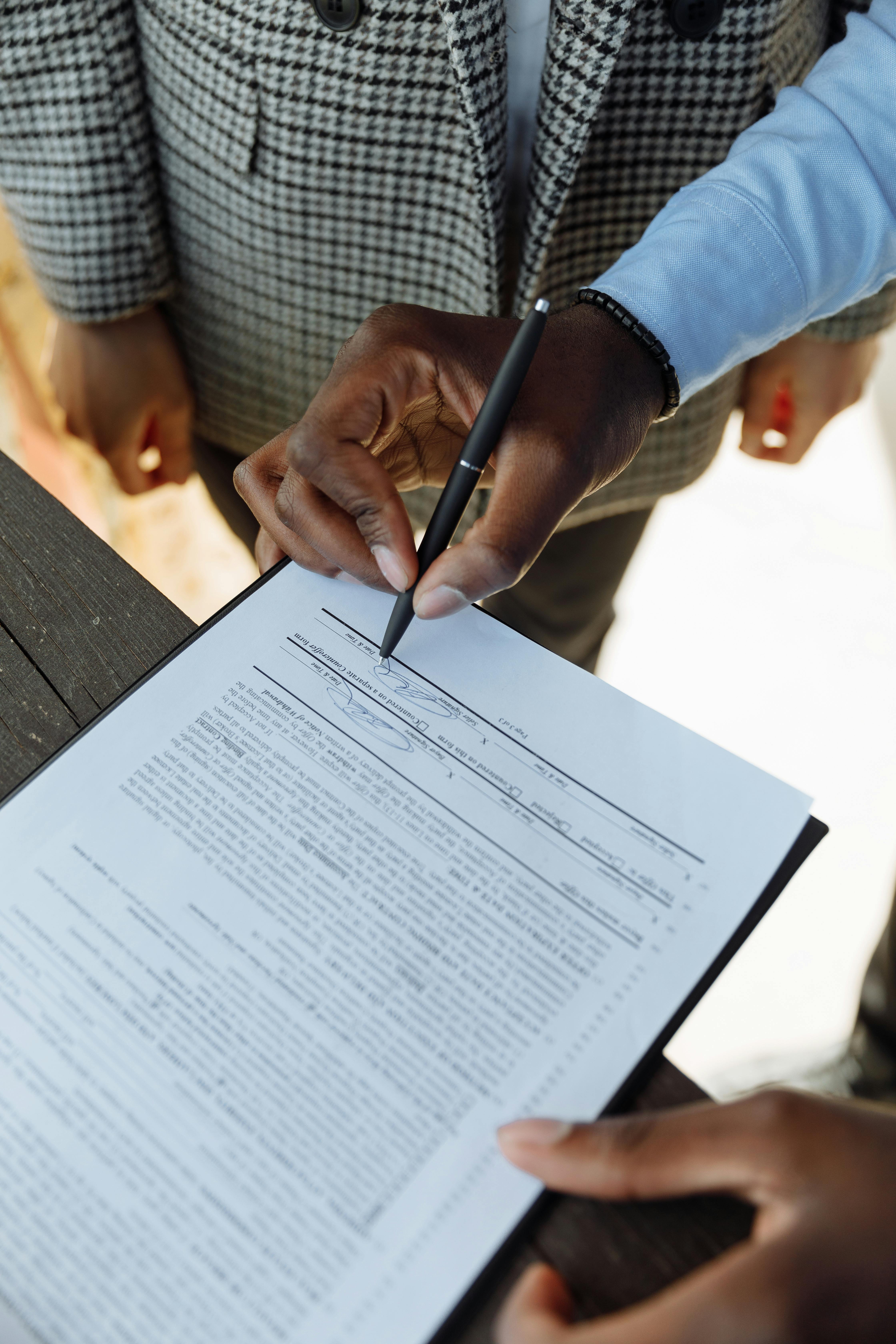 A Person Signing a Contract · Free Stock Photo