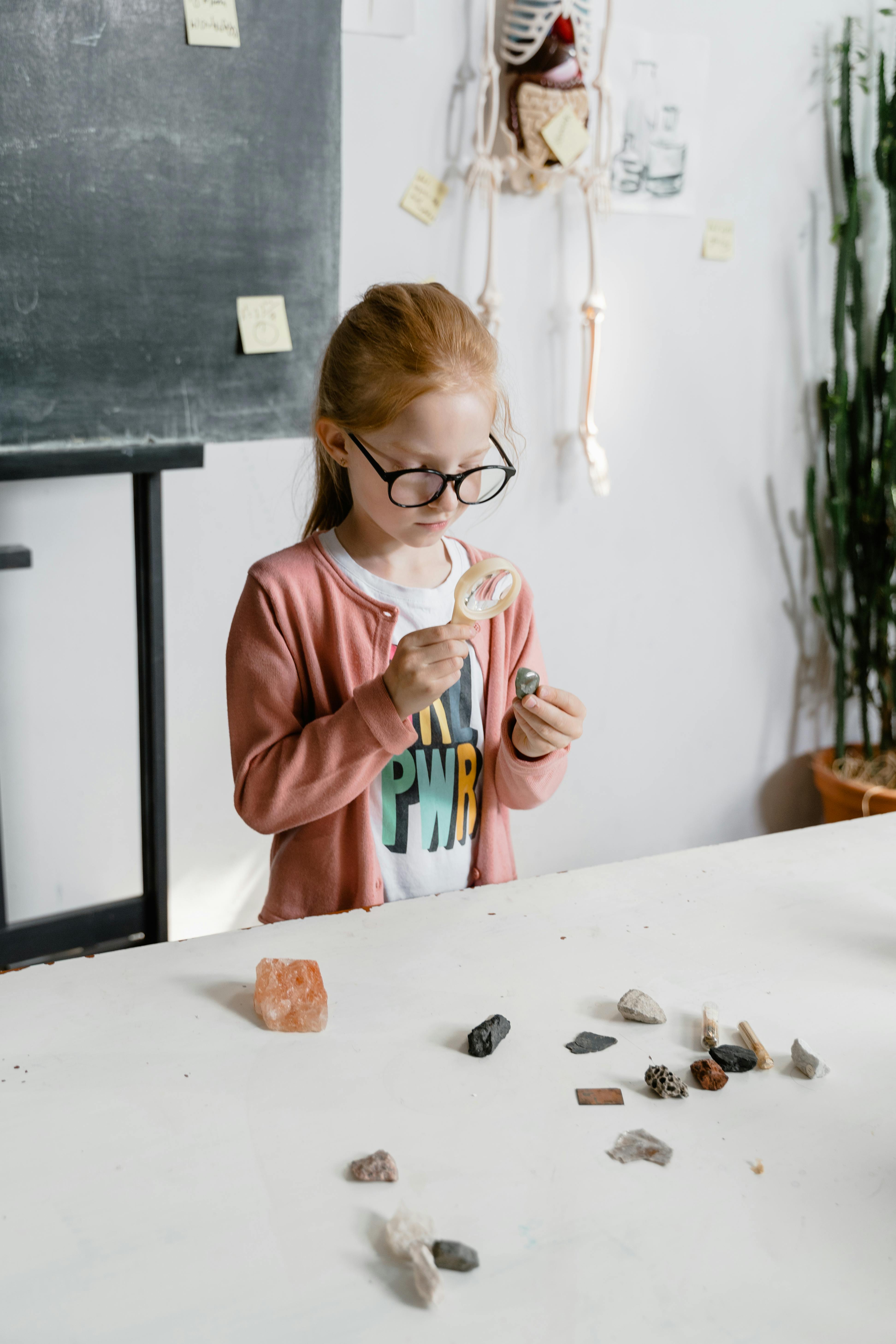 A Girl Looking at a Rock using a Magnifying Glass · Free Stock Photo
