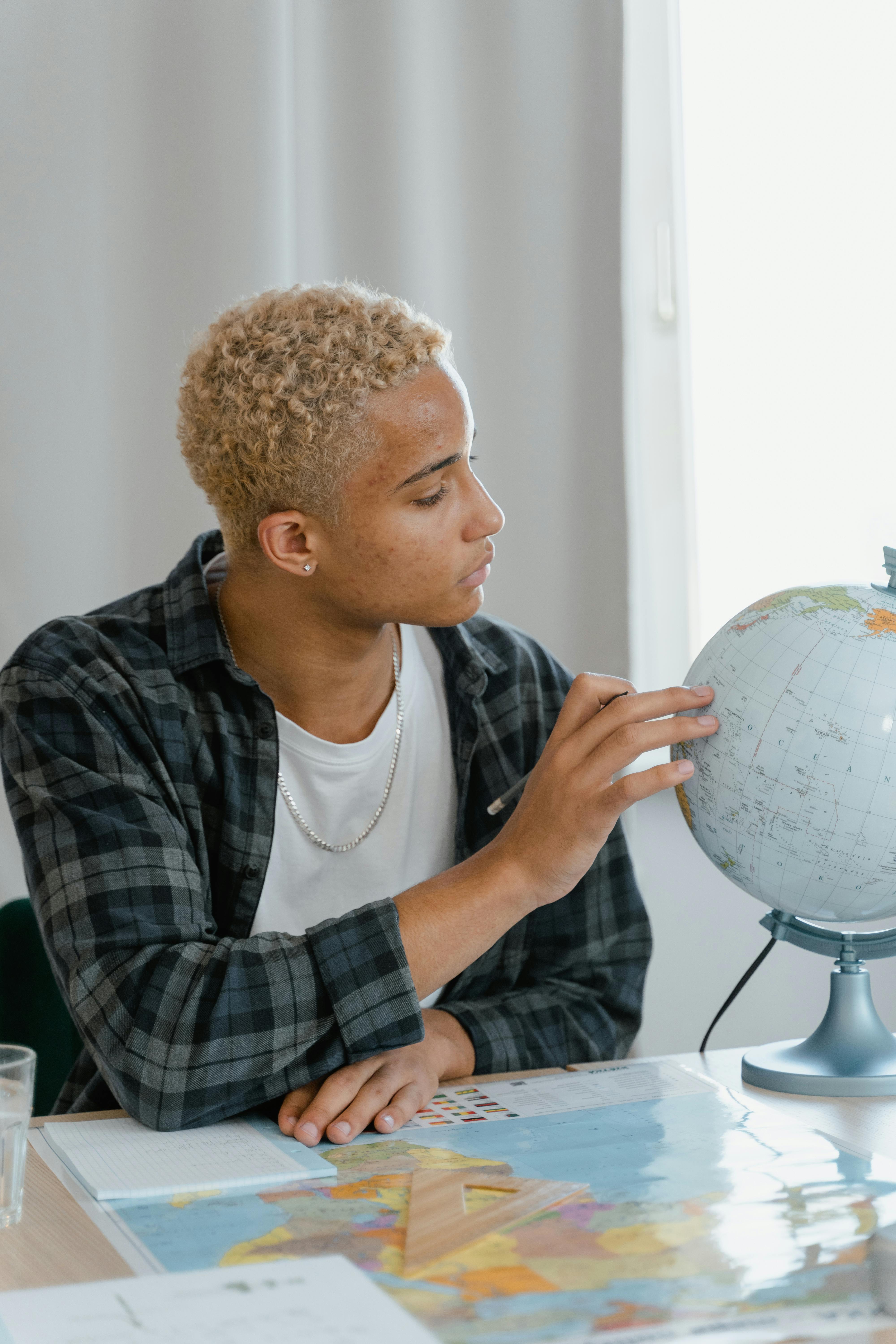 A Man Looking at a Globe · Free Stock Photo