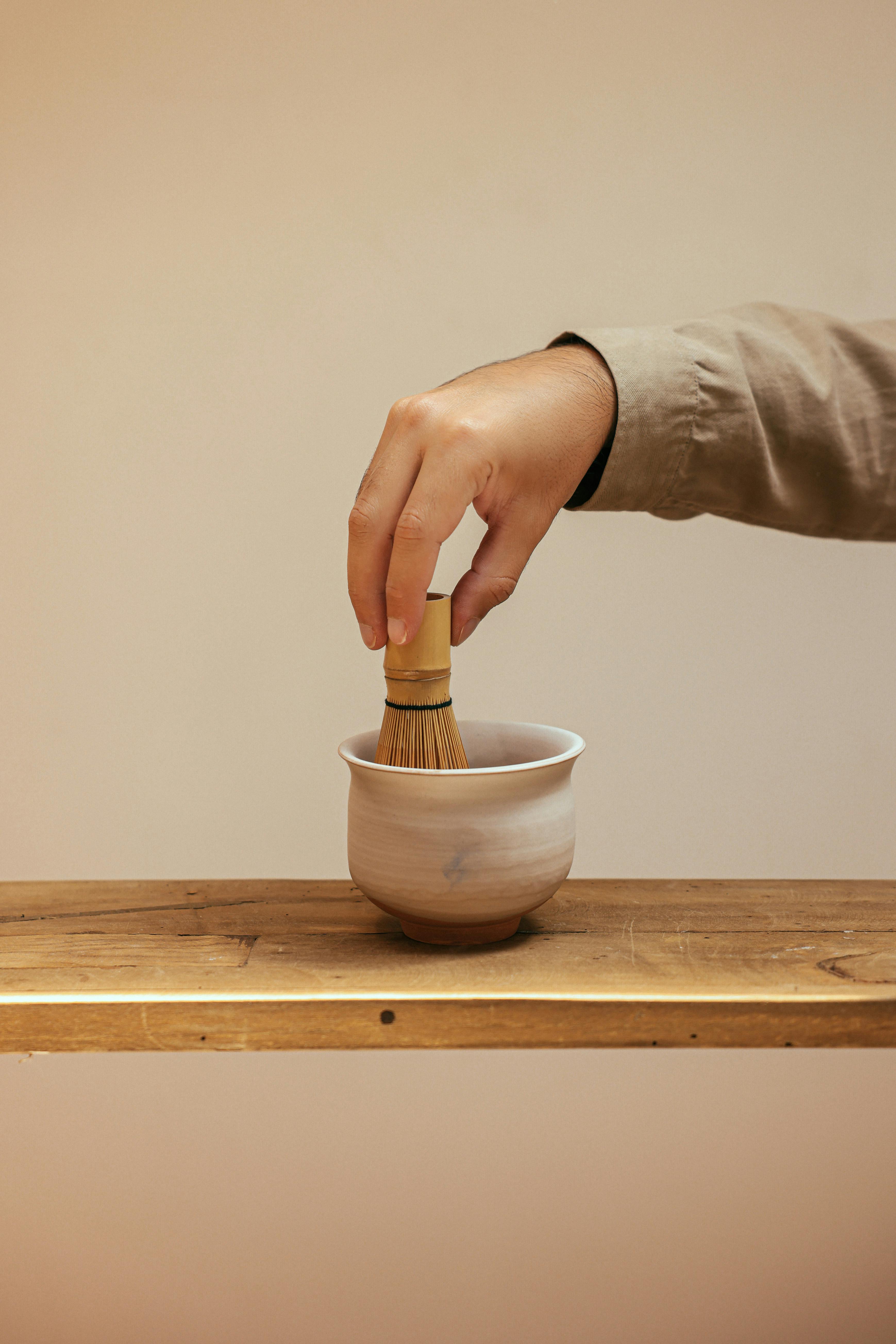 Person Mixing Tea using a Bamboo Whisk · Free Stock Photo