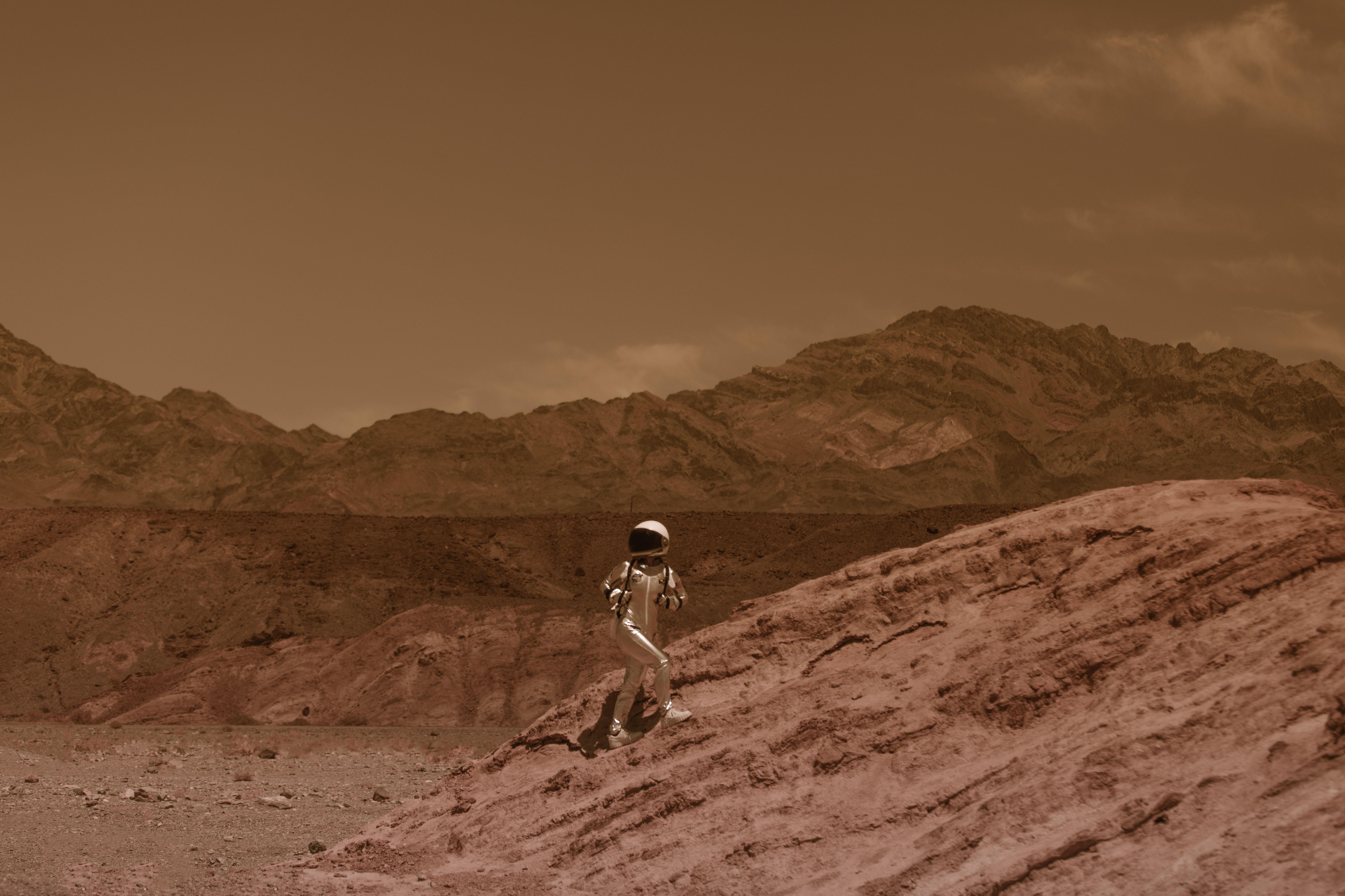 Astronauts Helping Each Other to Climb a Mountain · Free Stock Photo
