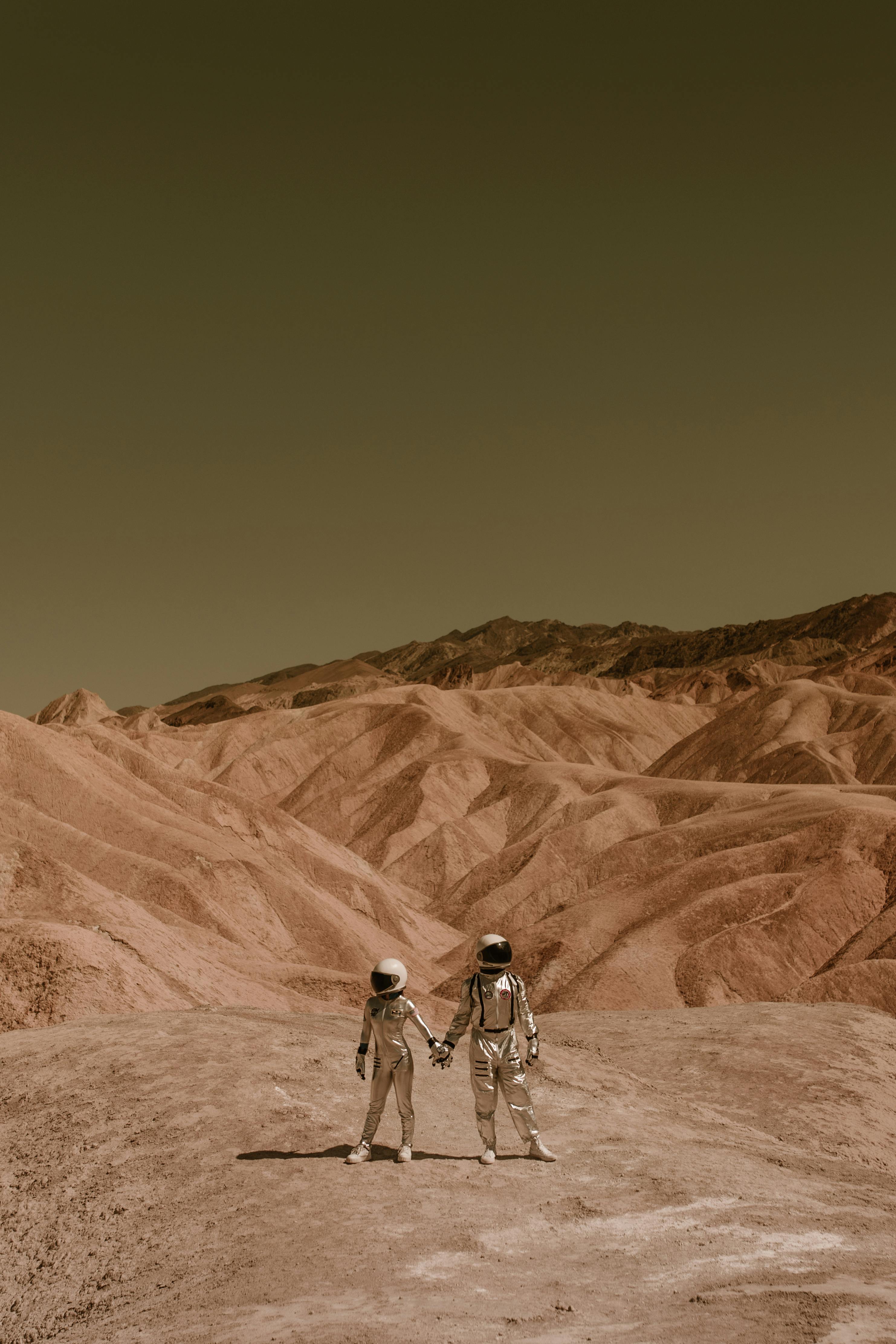 Astronauts Holding Hands on a Desolate Planet · Free Stock Photo