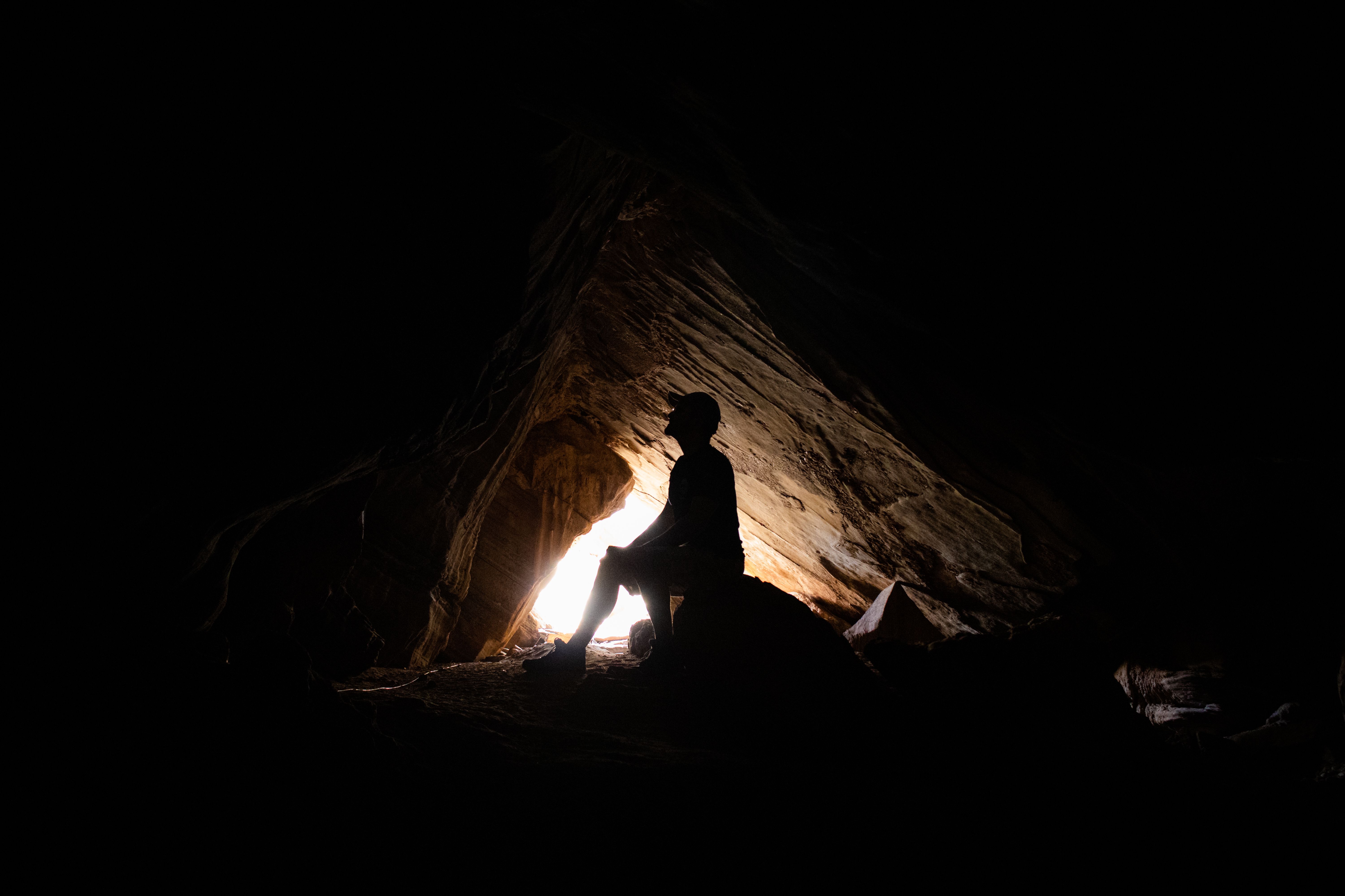 Back view Photo of Person Walking Out of a Cave · Free Stock Photo