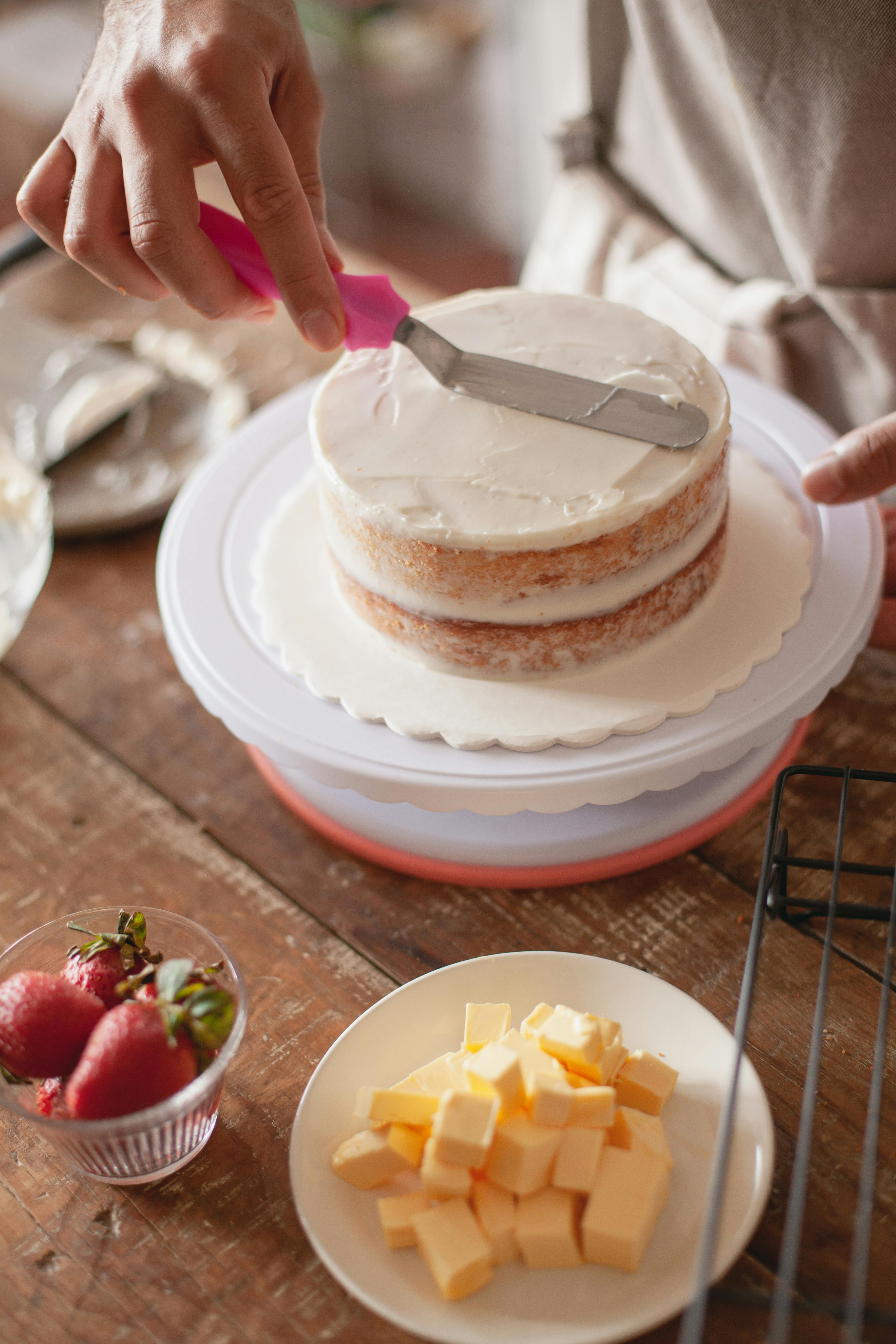 Person Putting Icing on a Cake · Free Stock Photo