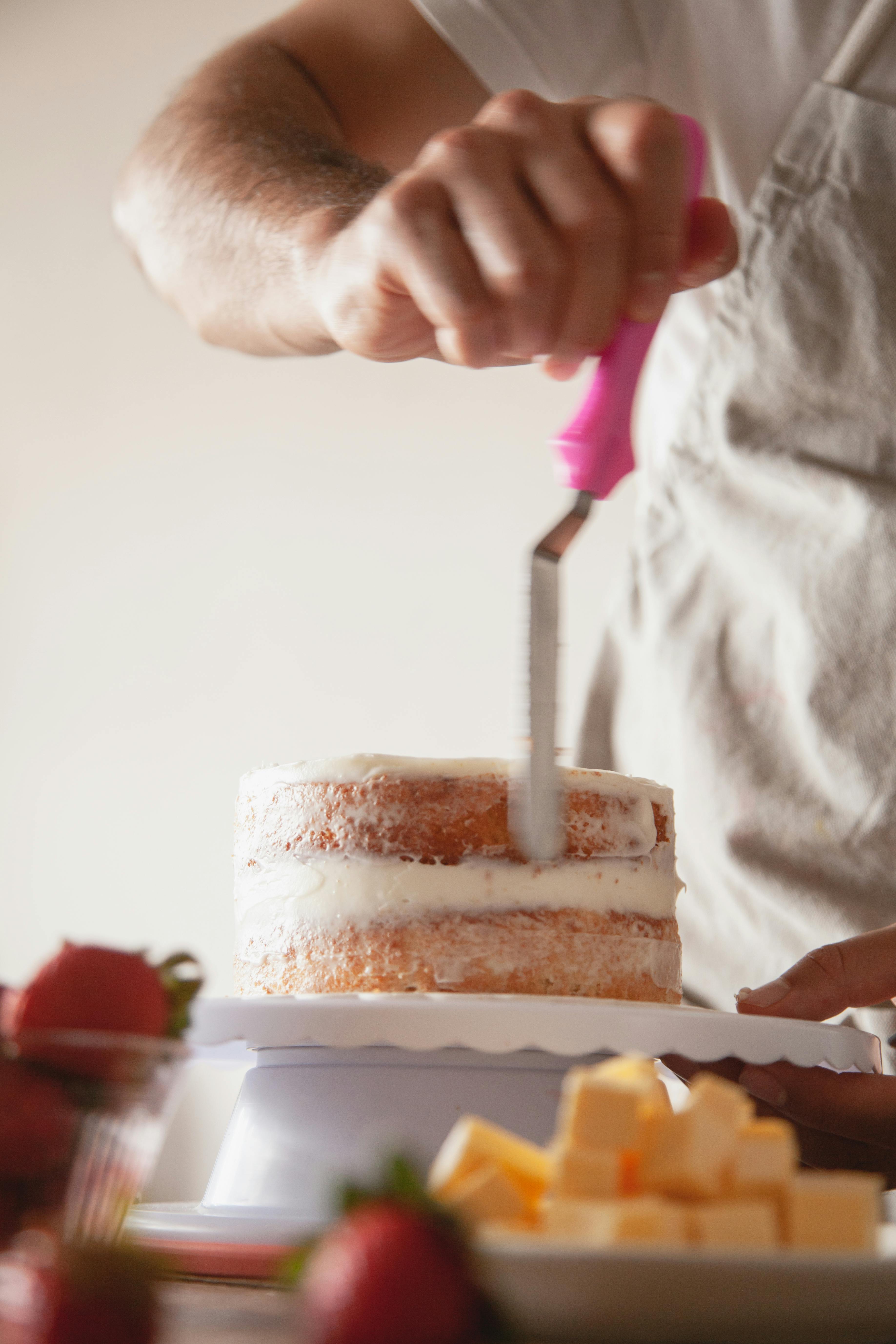 Person Putting Frosting on Cake · Free Stock Photo