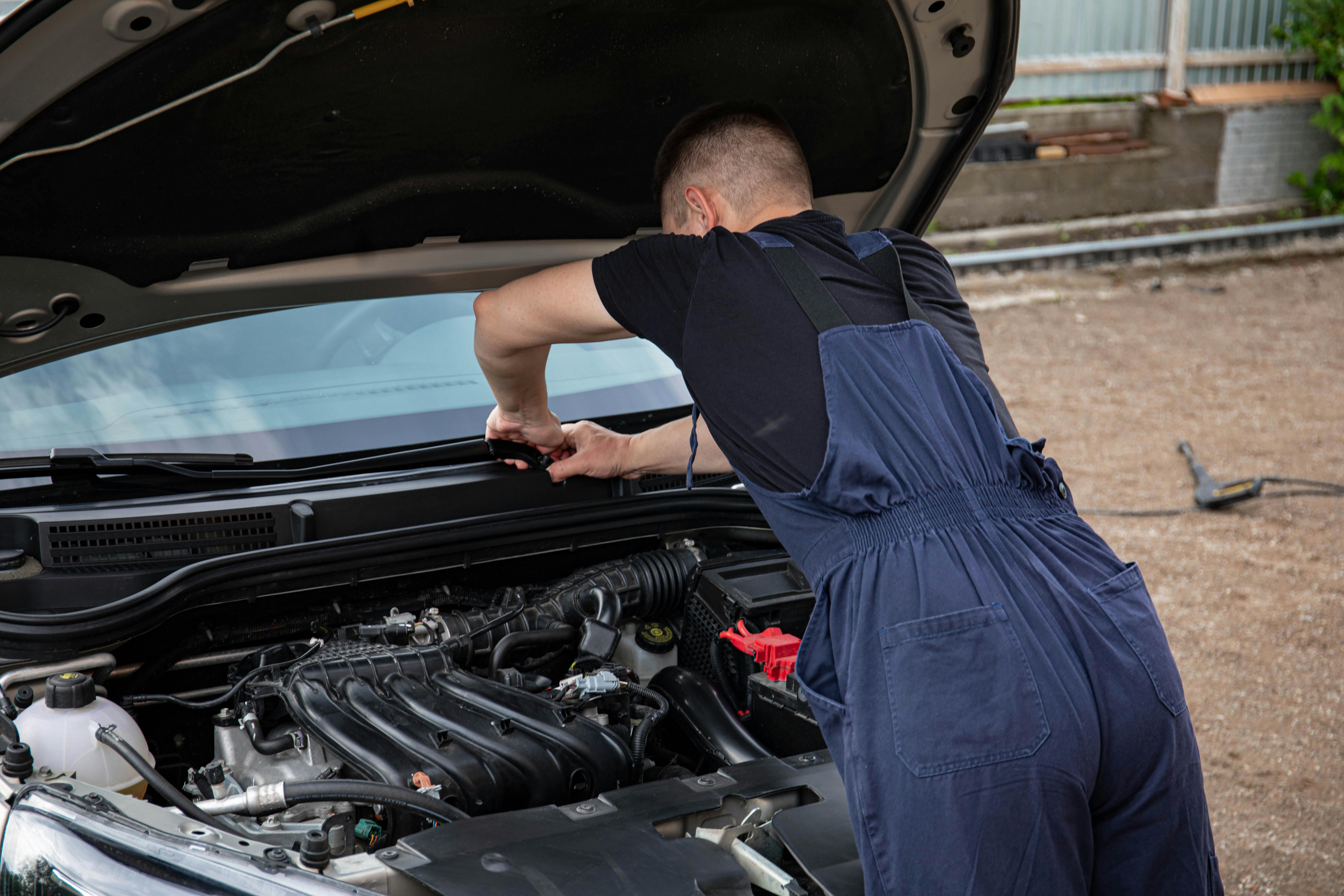 Man in Black Crew Neck T Shirt Fixing a Car · Free Stock Photo