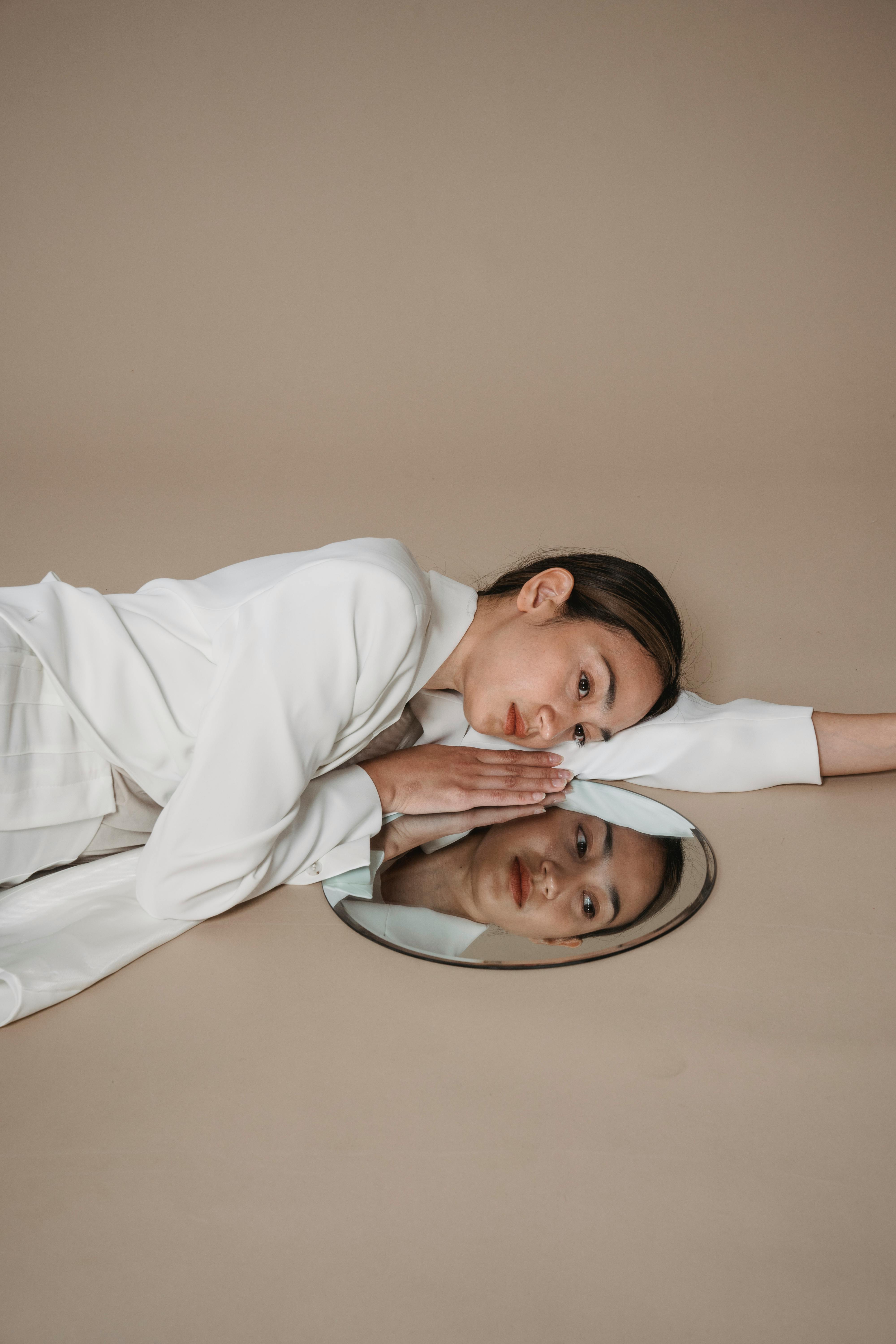 Woman Lying on the Floor with a Round Mirror near her Face · Free Stock ...