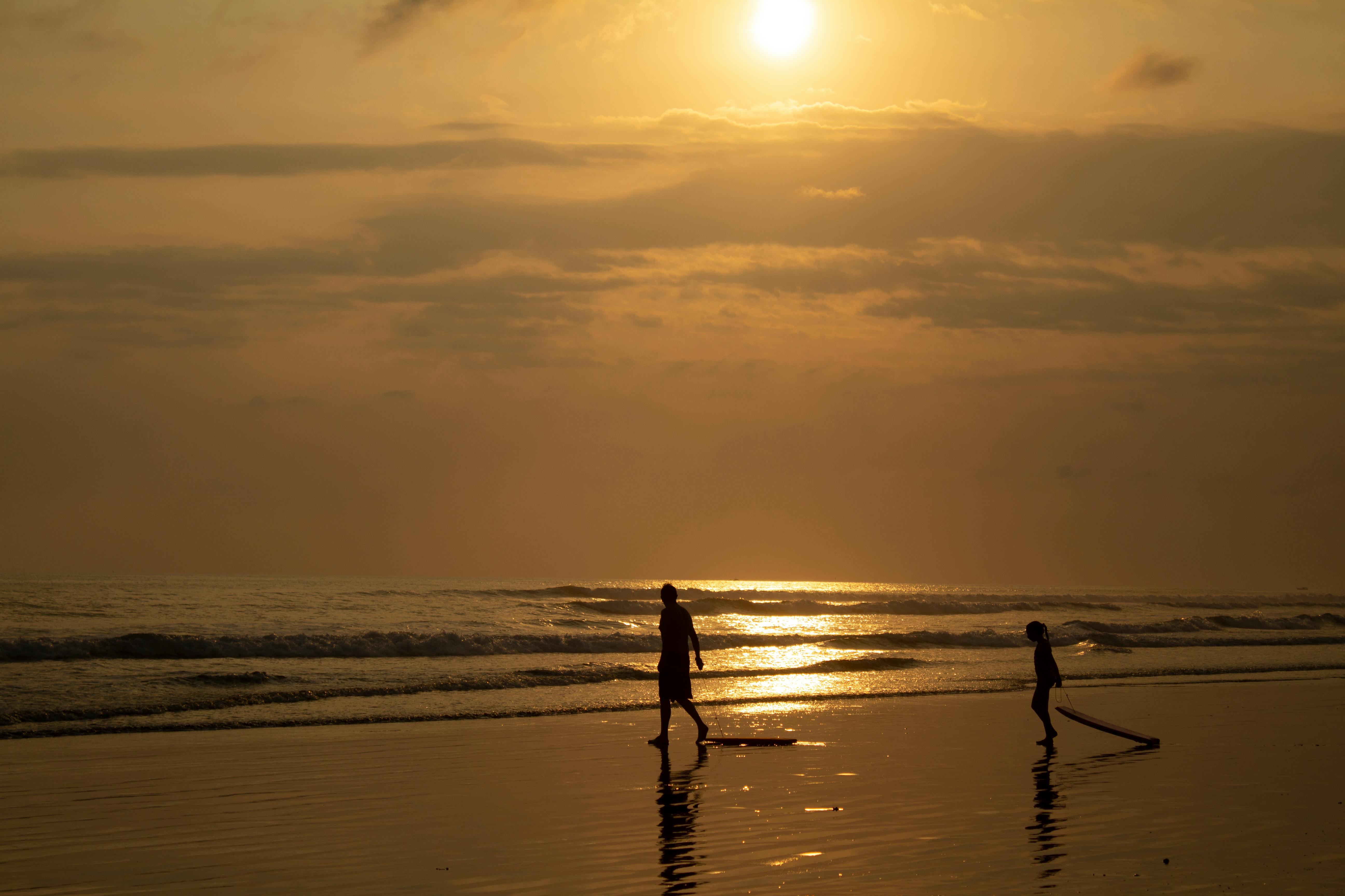 Woman Walking on Beach at Sunset · Free Stock Photo