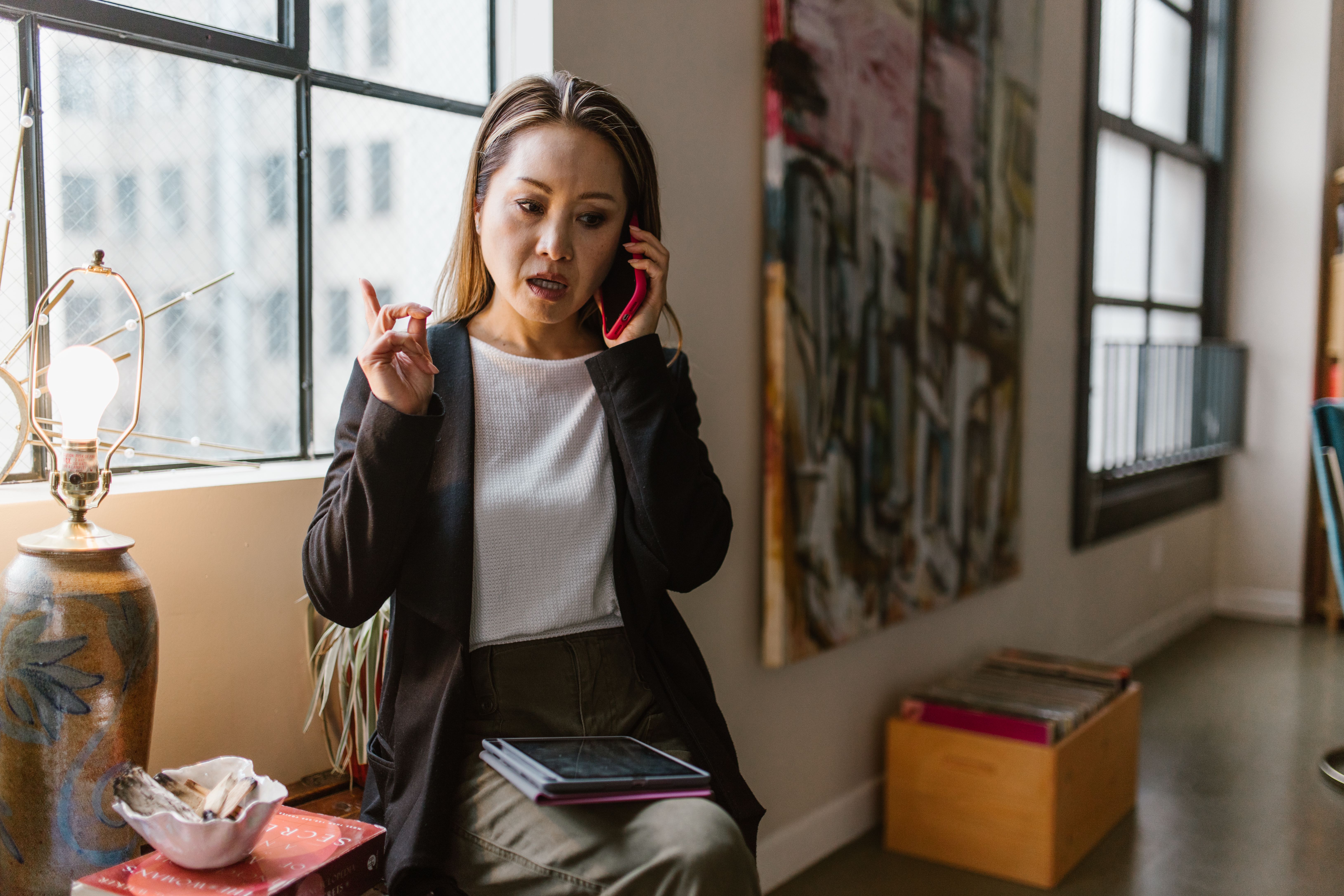 Woman Sitting Talking to Someone Using Her Smartphone · Free Stock Photo