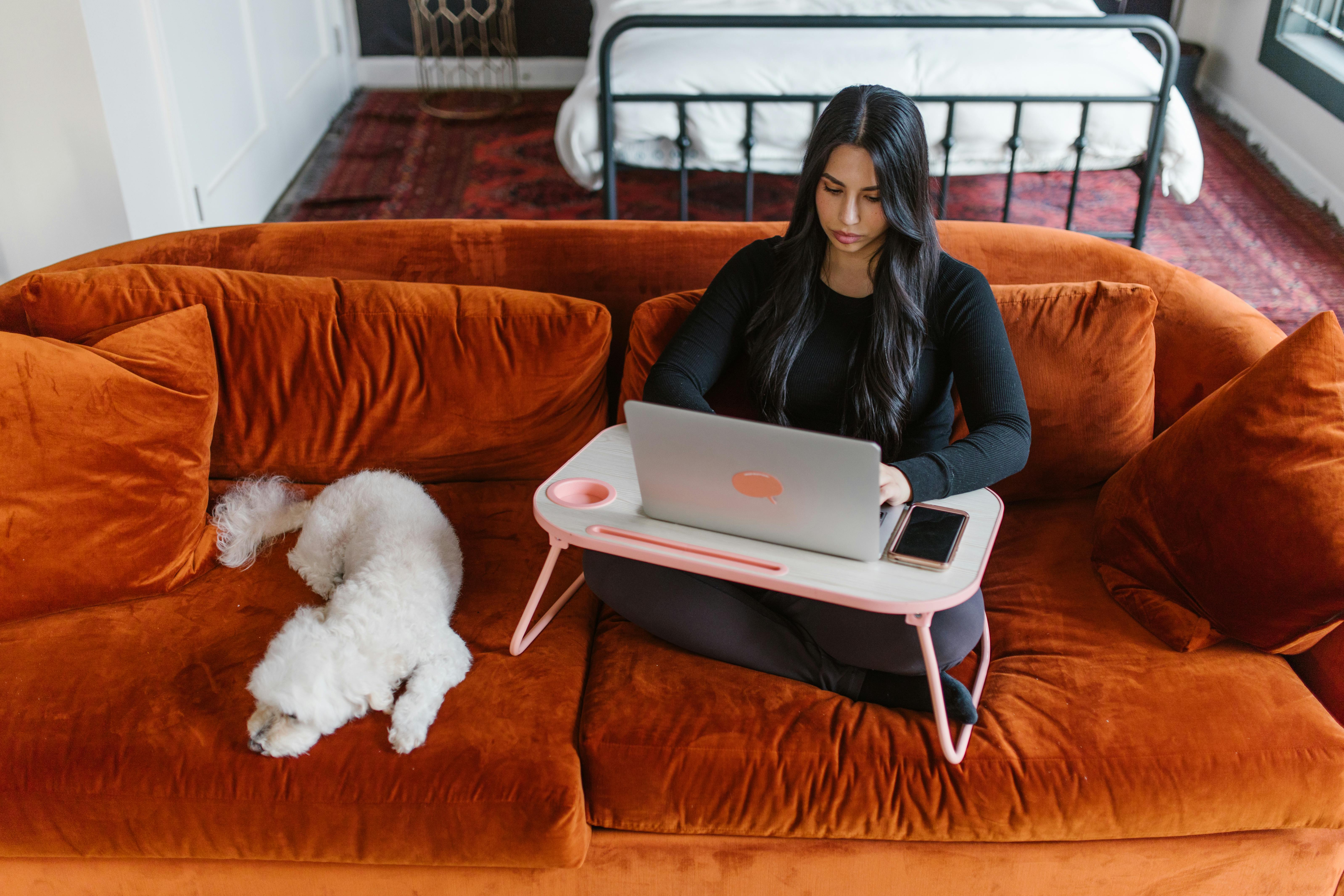 Woman Using her Laptop While Sitting Beside her Dog · Free Stock Photo