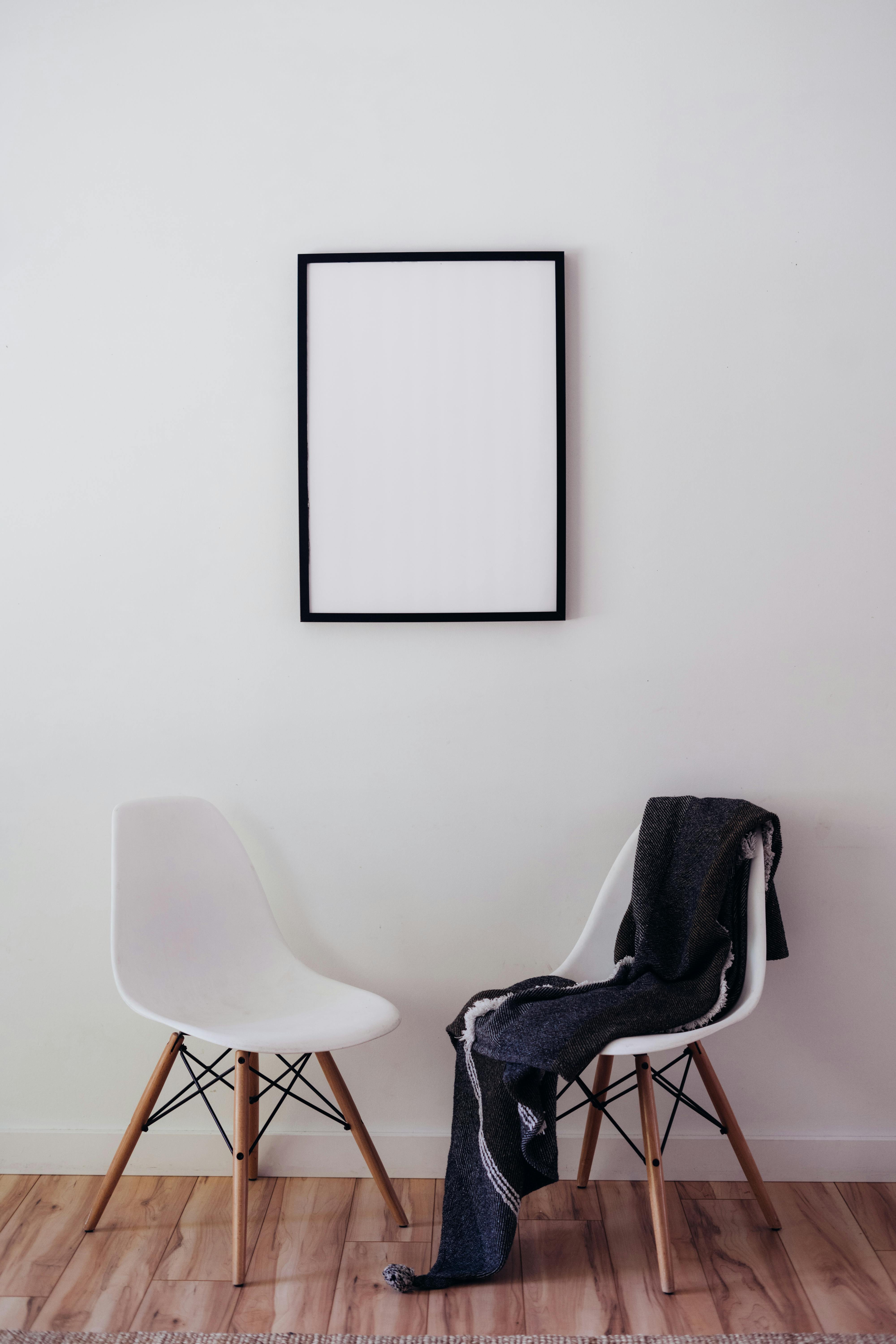 Two Chairs and Blank Frame Hanging on the Wall · Free Stock Photo
