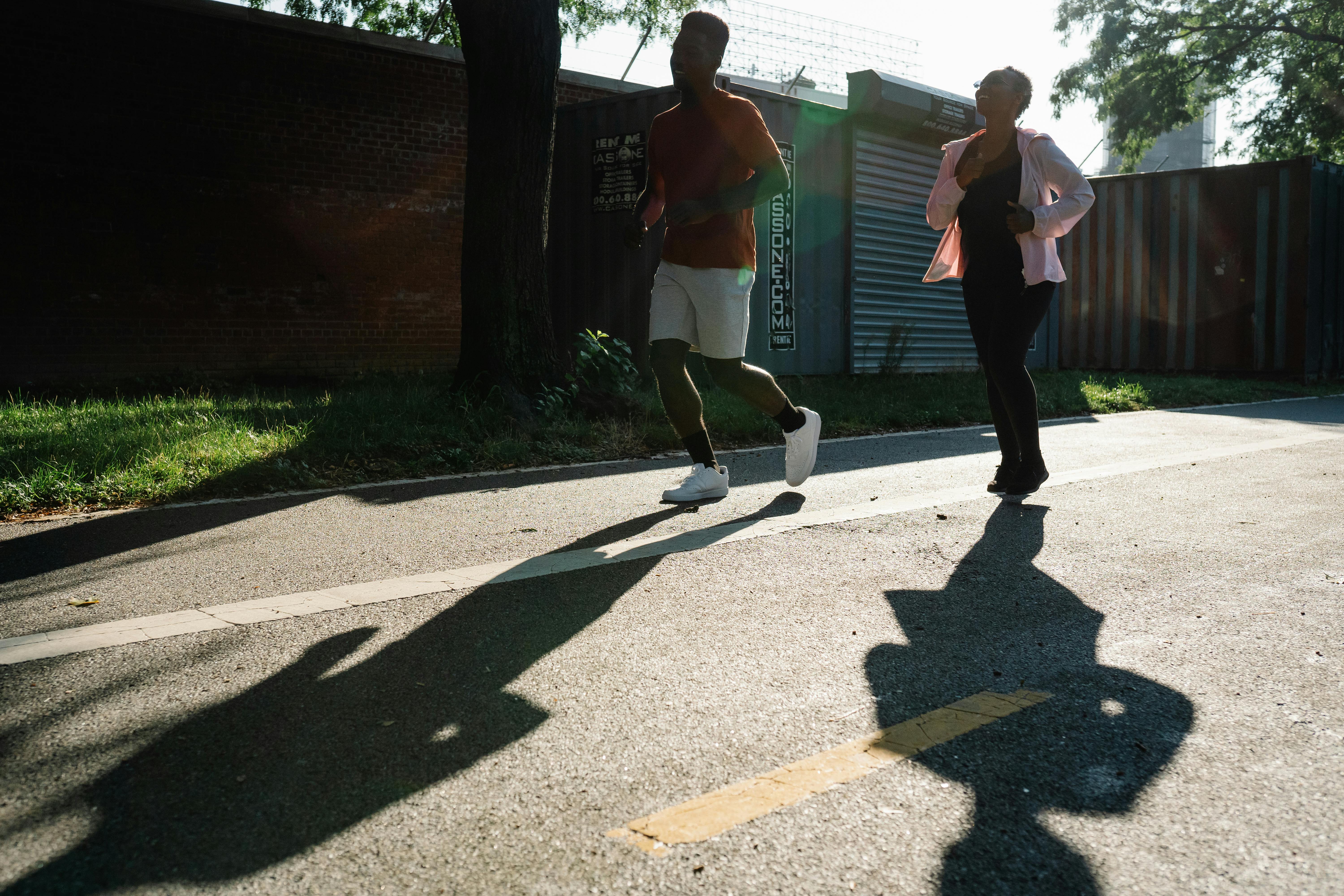 Man and Woman Jogging on Sidewalk · Free Stock Photo