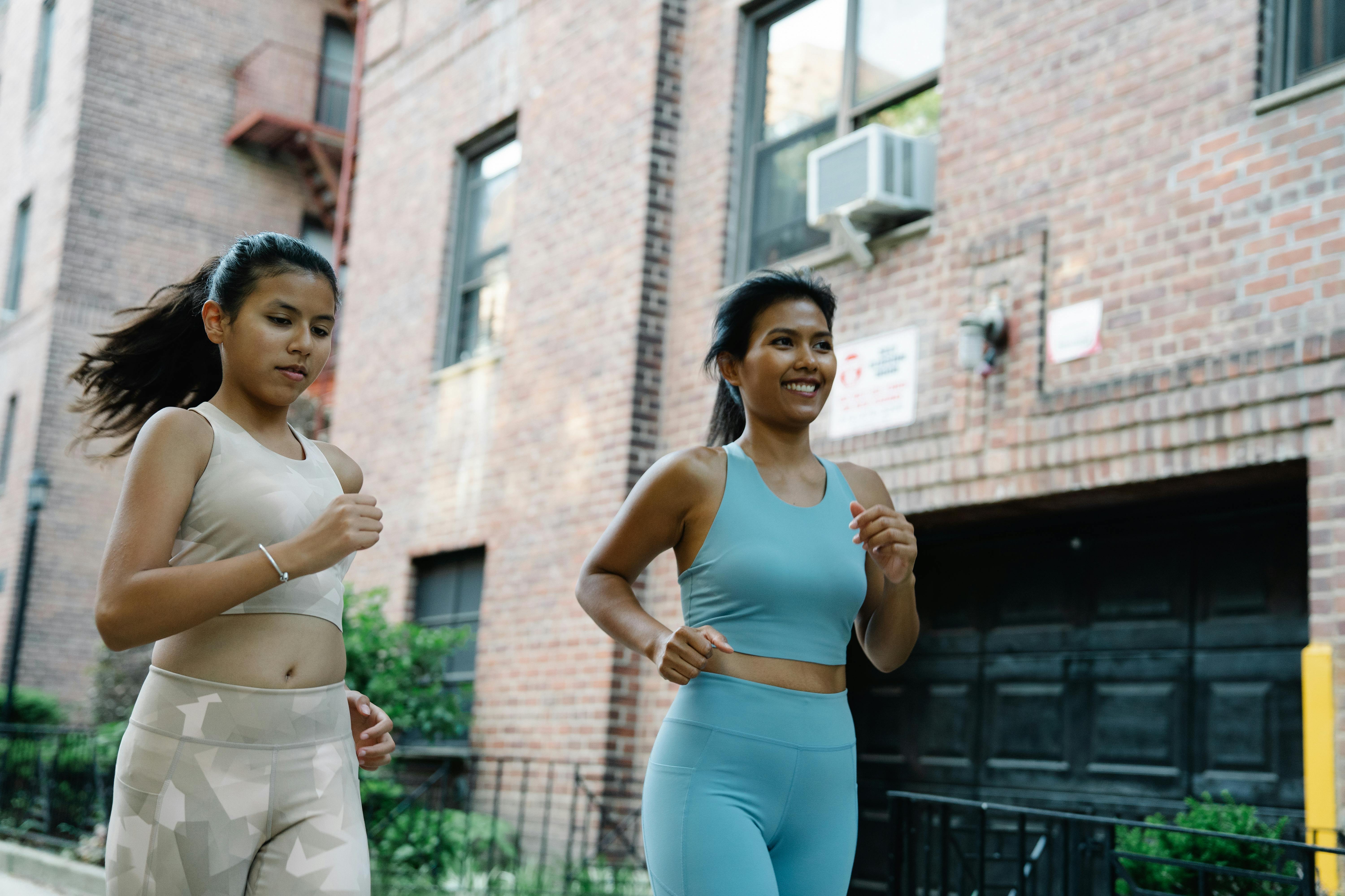 Women Jogs Near the House with Brick Wall · Free Stock Photo