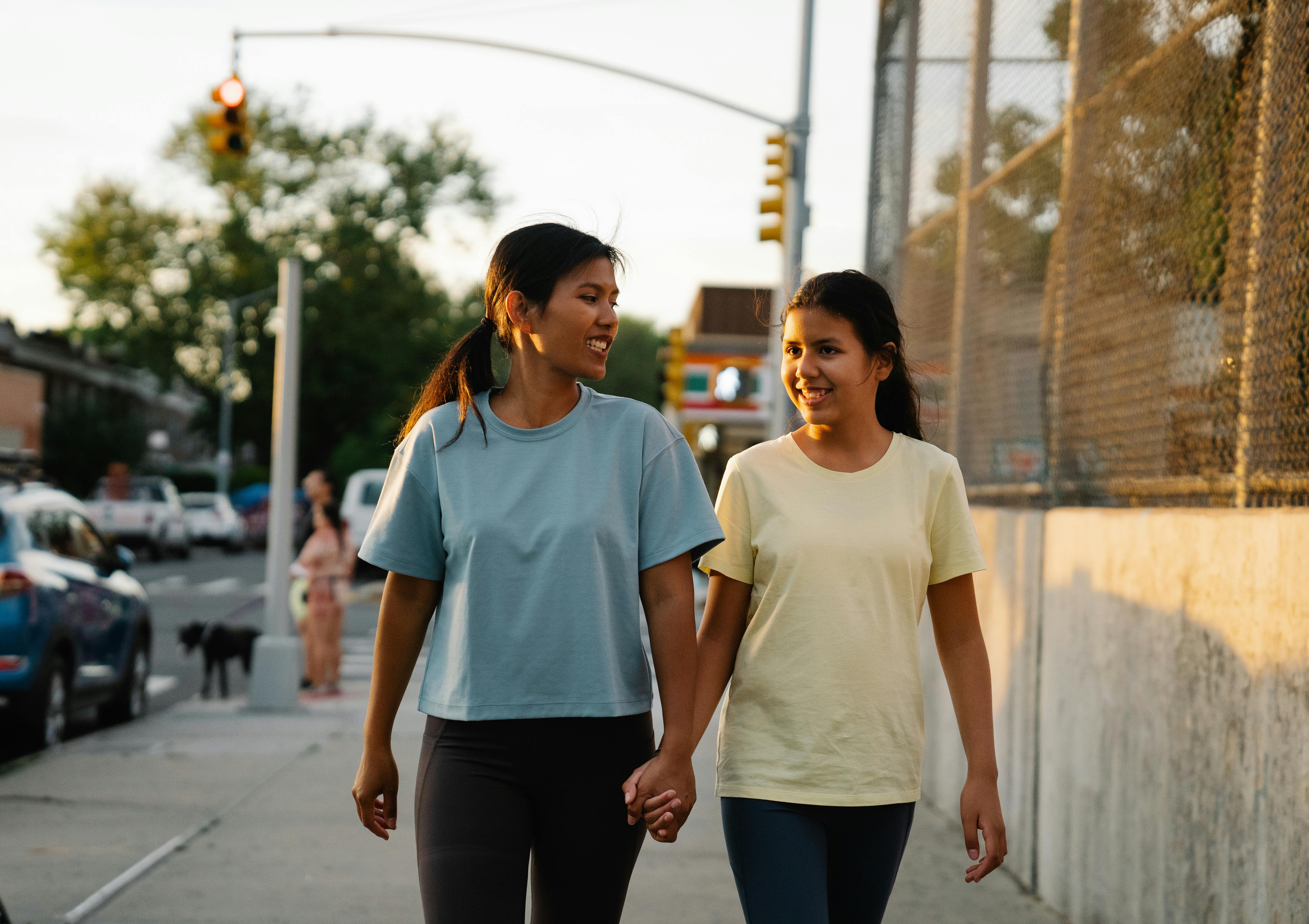 Woman Holding the Hand of a Girl While Walking · Free Stock Photo
