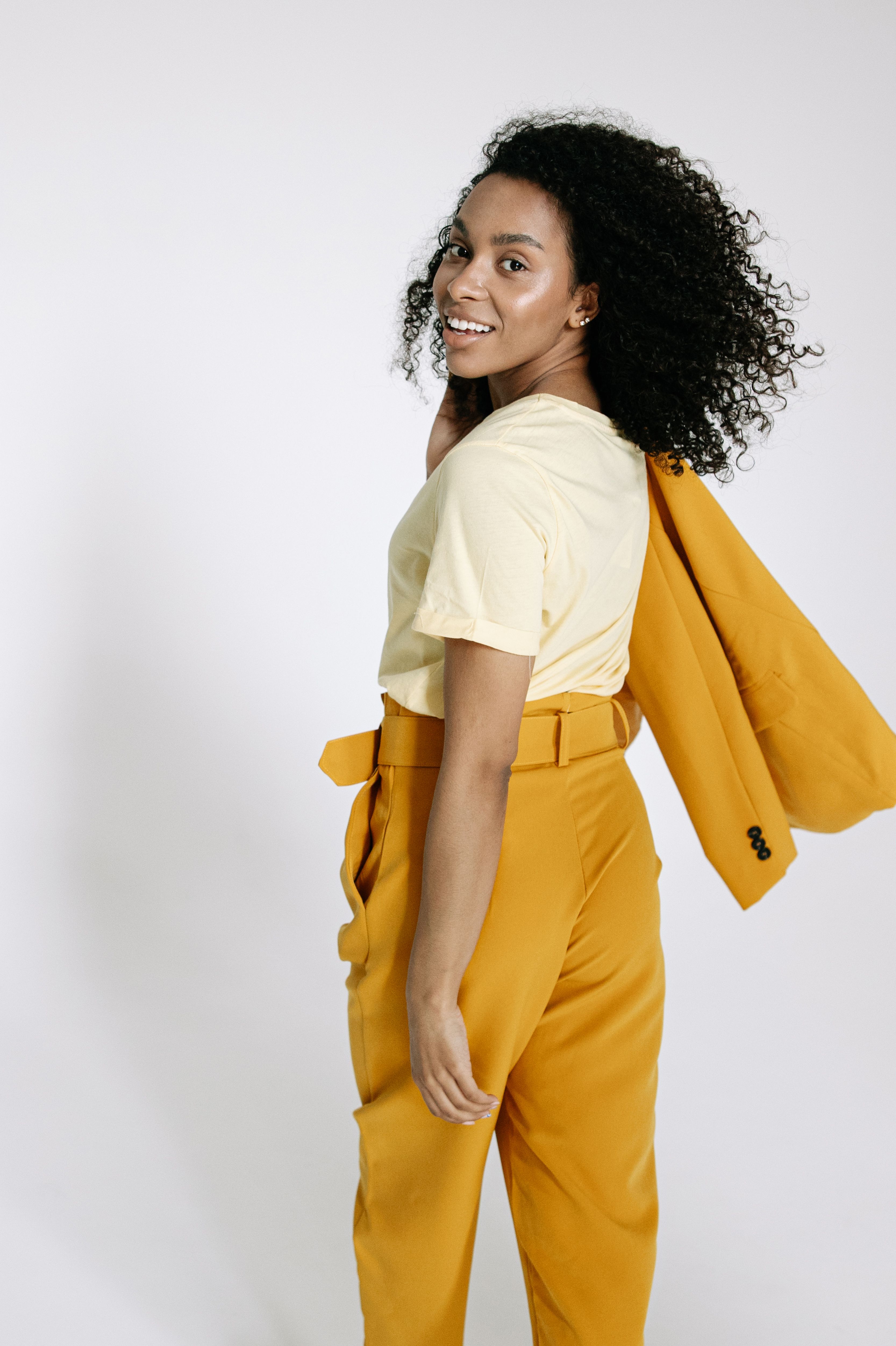 Woman in Yellow Outfit with Her Coat Over Her Shoulder · Free Stock Photo