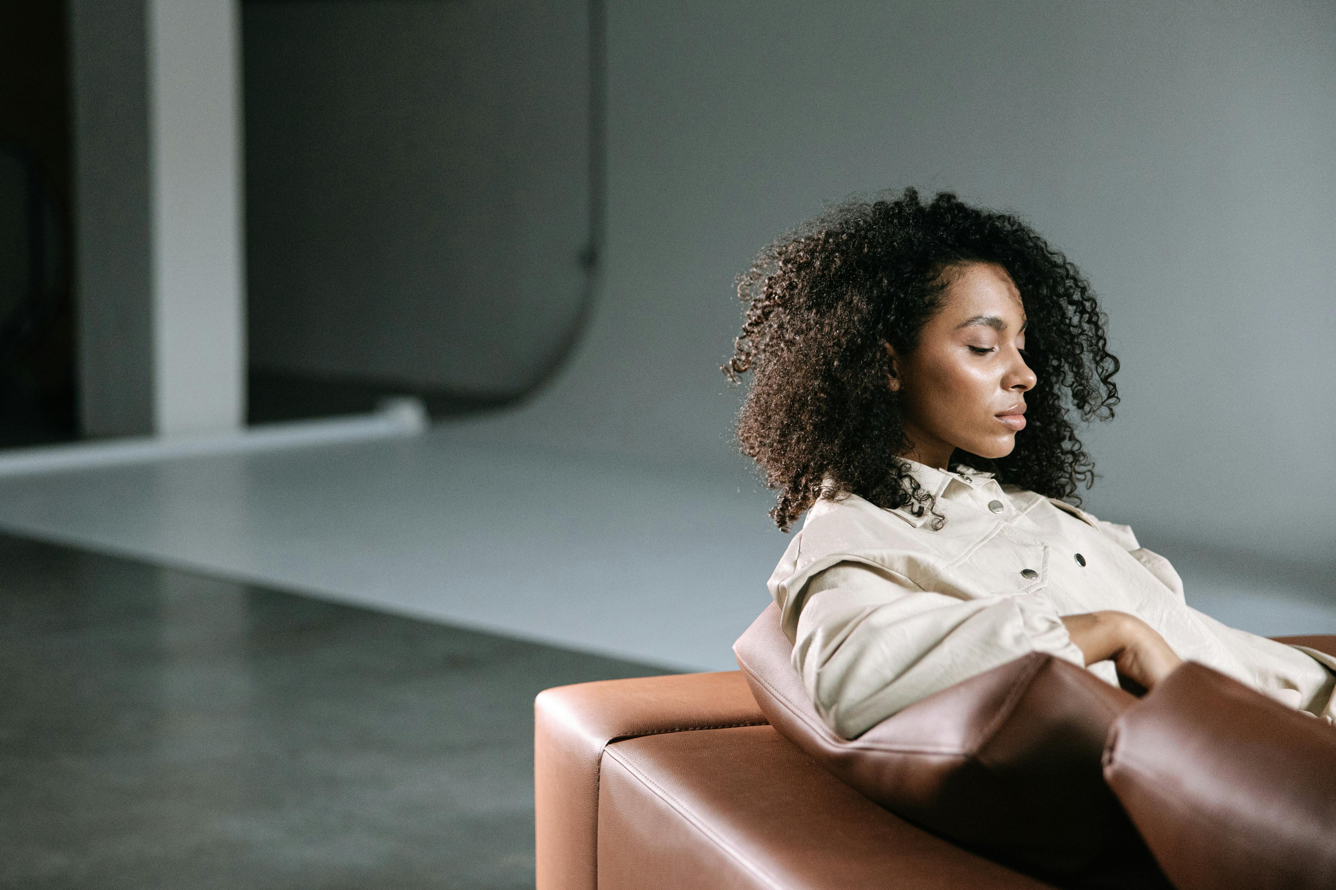 Woman Sitting on a Leather Couch · Free Stock Photo
