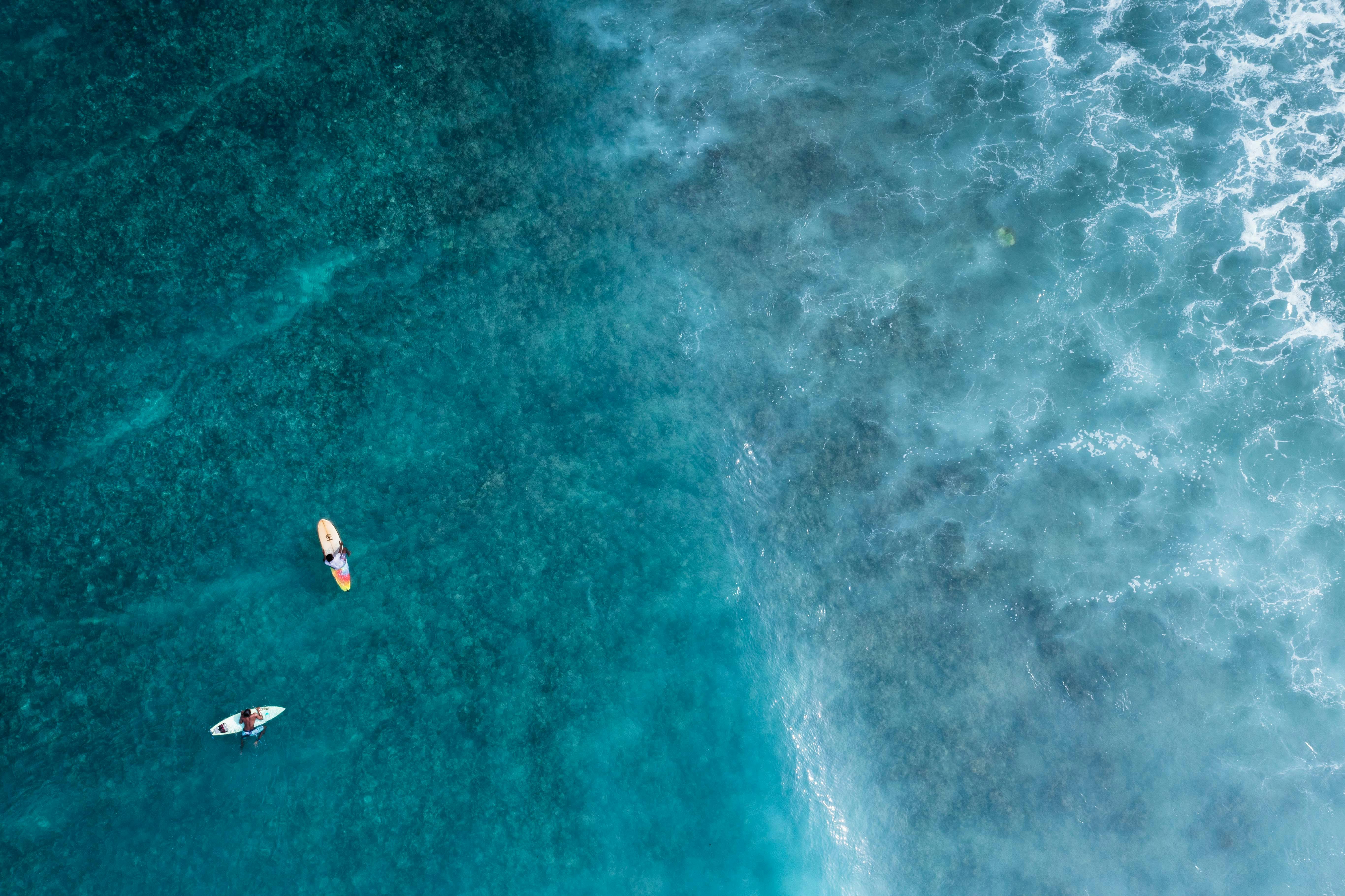 Person Sitting on the Surfboard on the Sea · Free Stock Photo