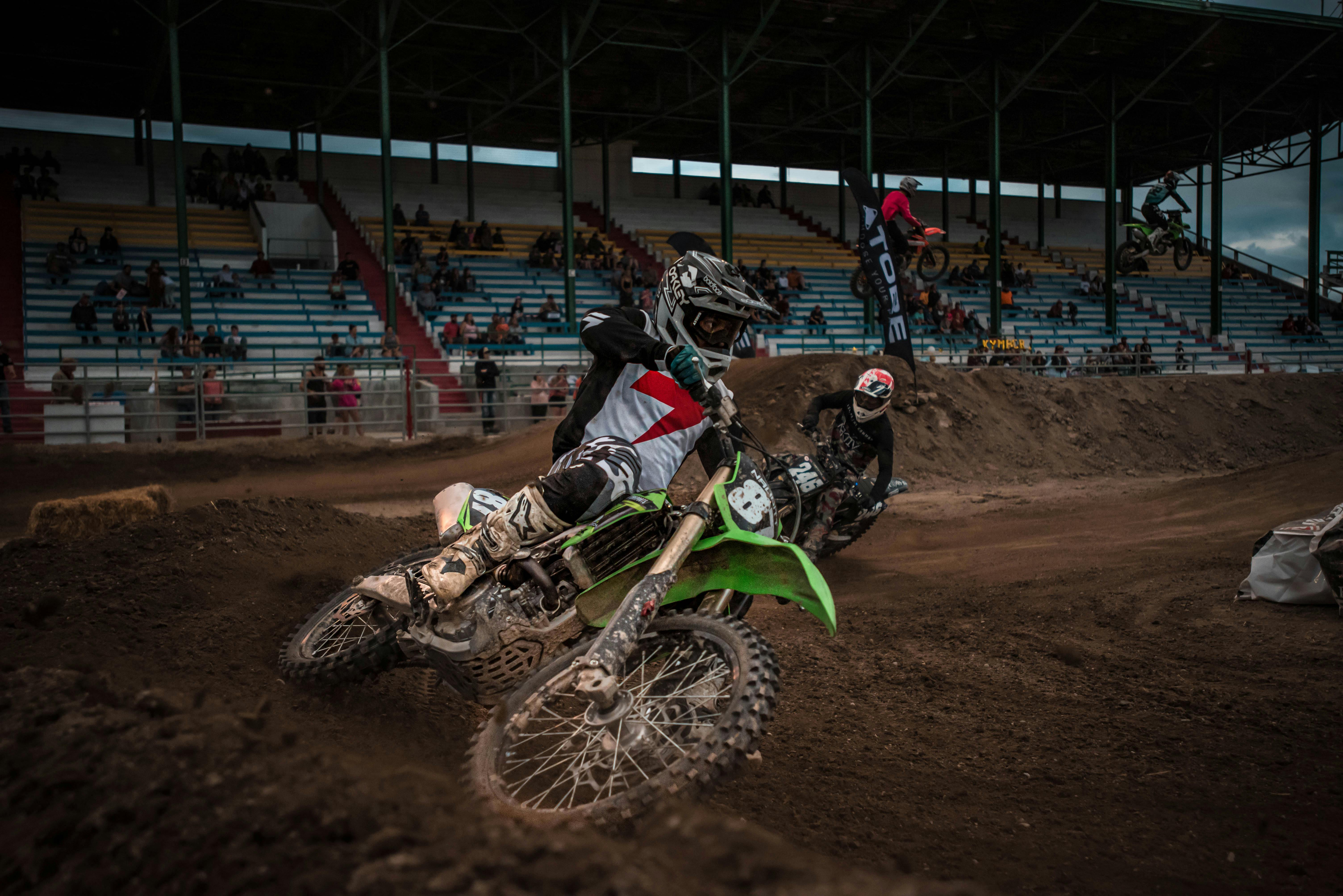Men Riding on Motorbikes on a Stadium with Dust · Free Stock Photo