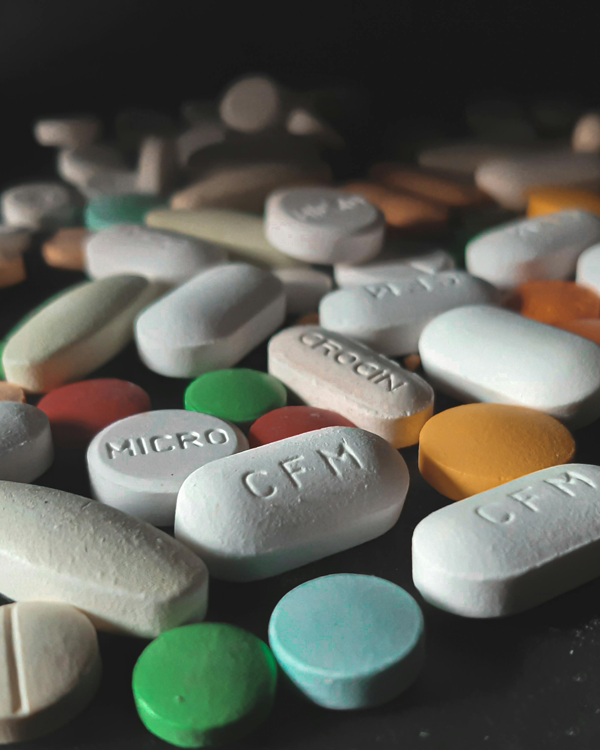 A hand below pill vial mid-air · Free Stock Photo