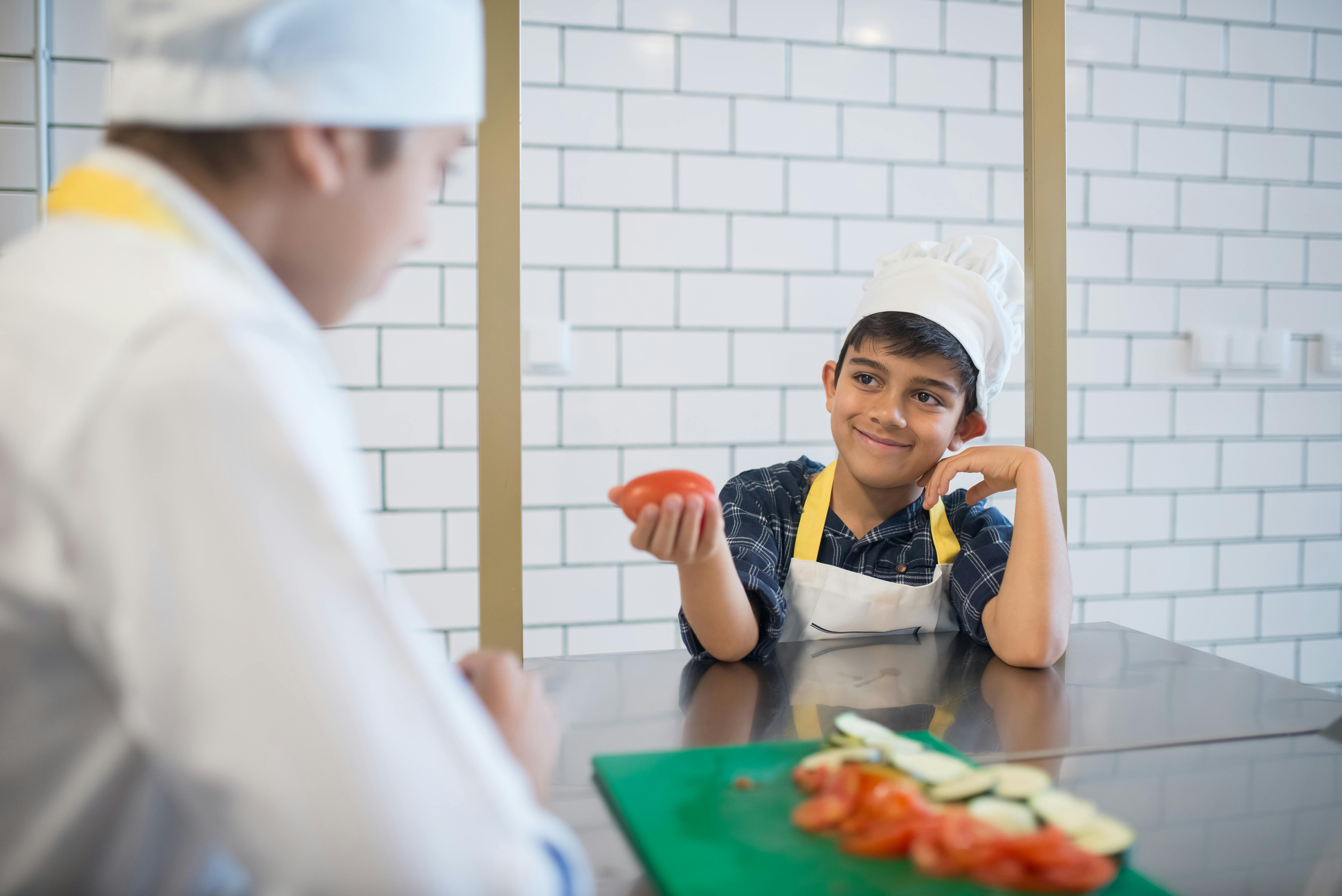 A Young Girl Putting Toppings on a Pizza · Free Stock Photo