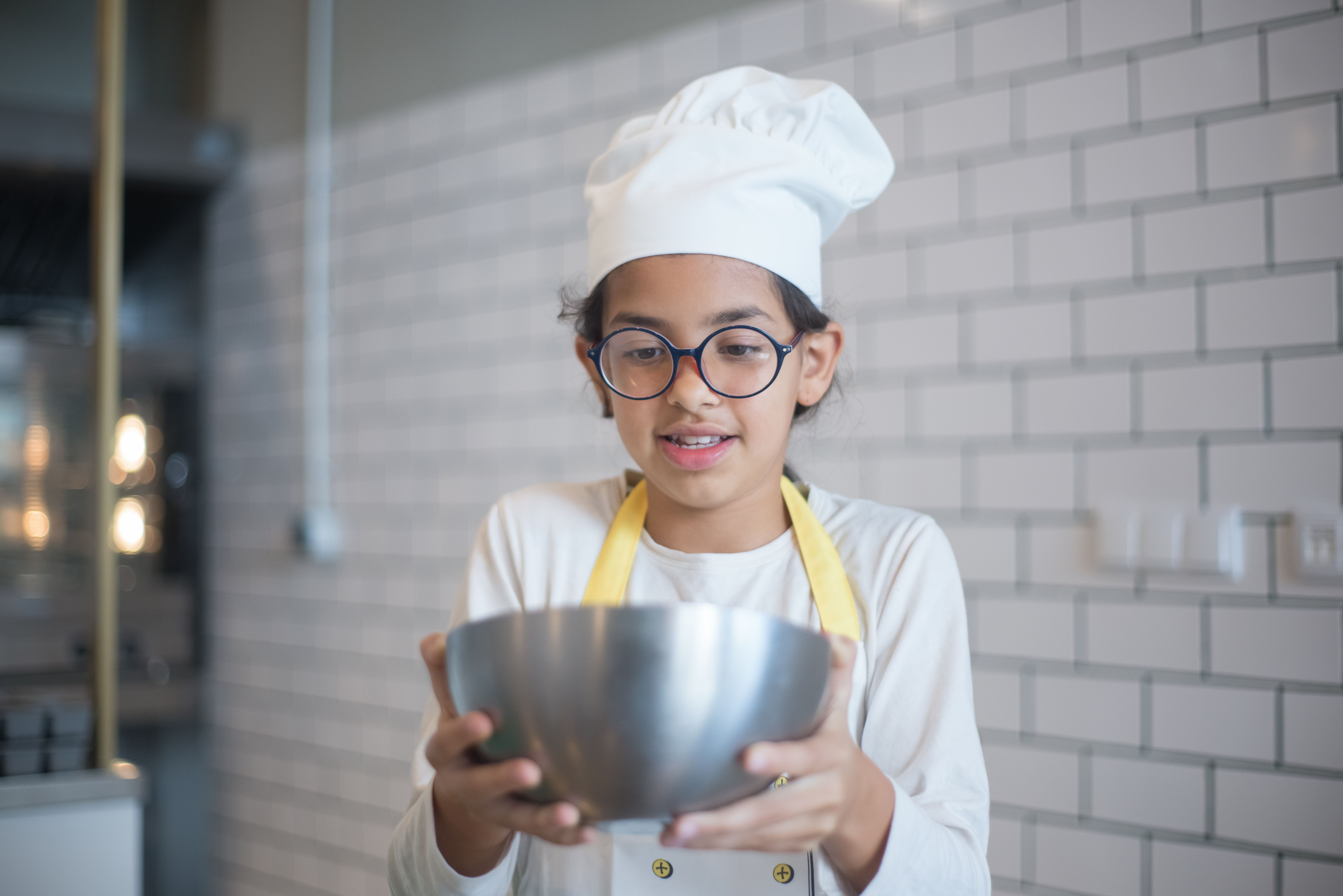 Girl in White Chef's Hat Wearing Eyeglasses while Holding a Stainless ...
