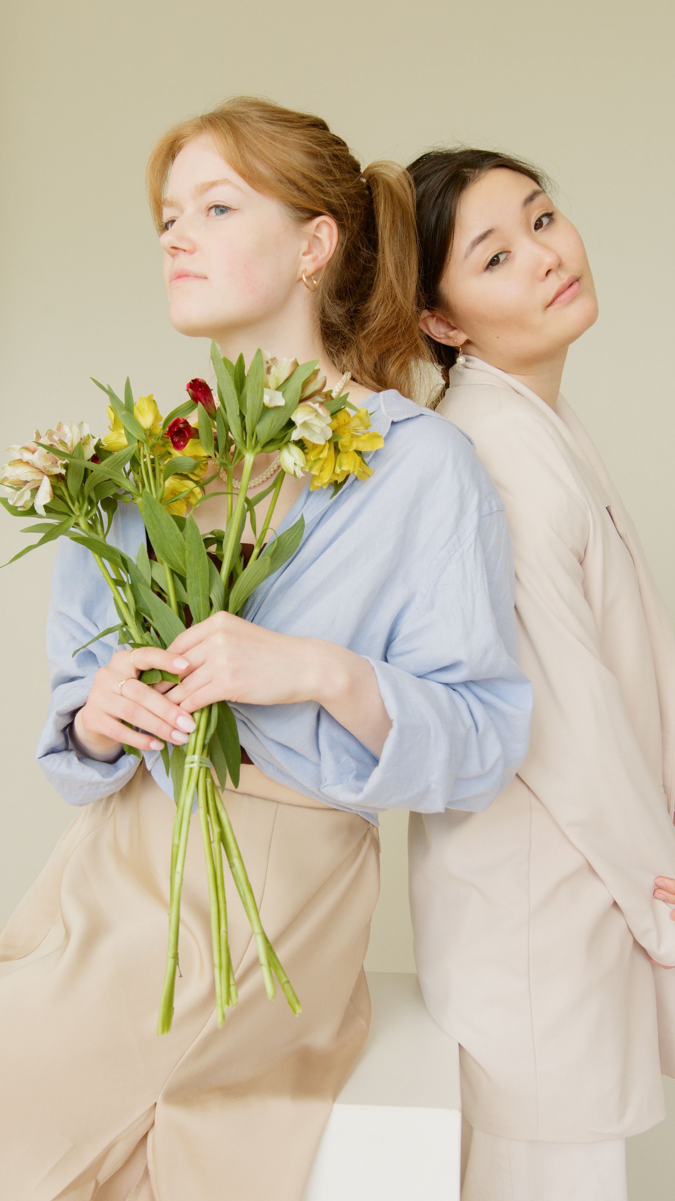 A Woman Leaning on Another Woman with Flowers · Free Stock Photo