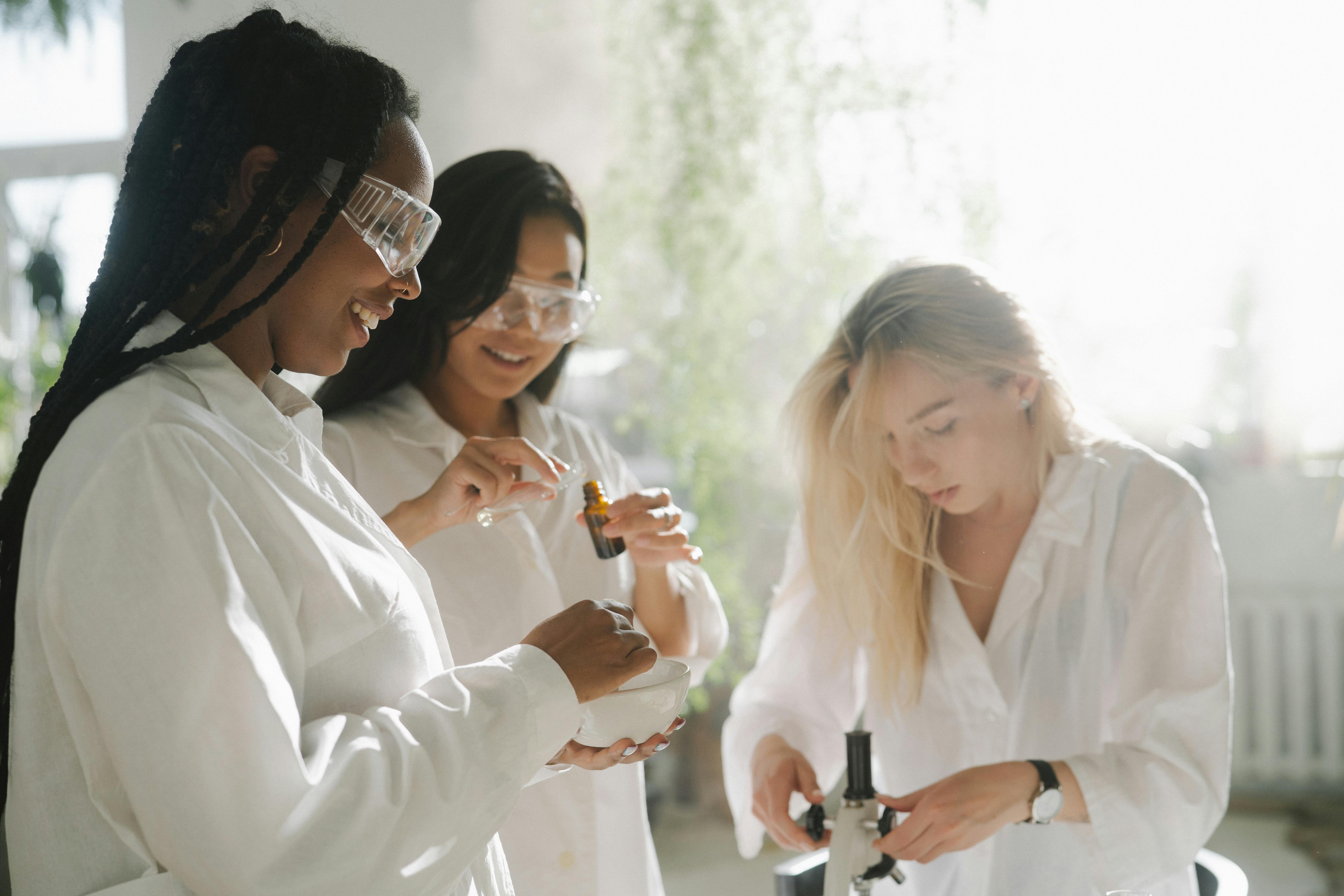 Women in Lab Coats with Test Tubes and Microscope · Free Stock Photo