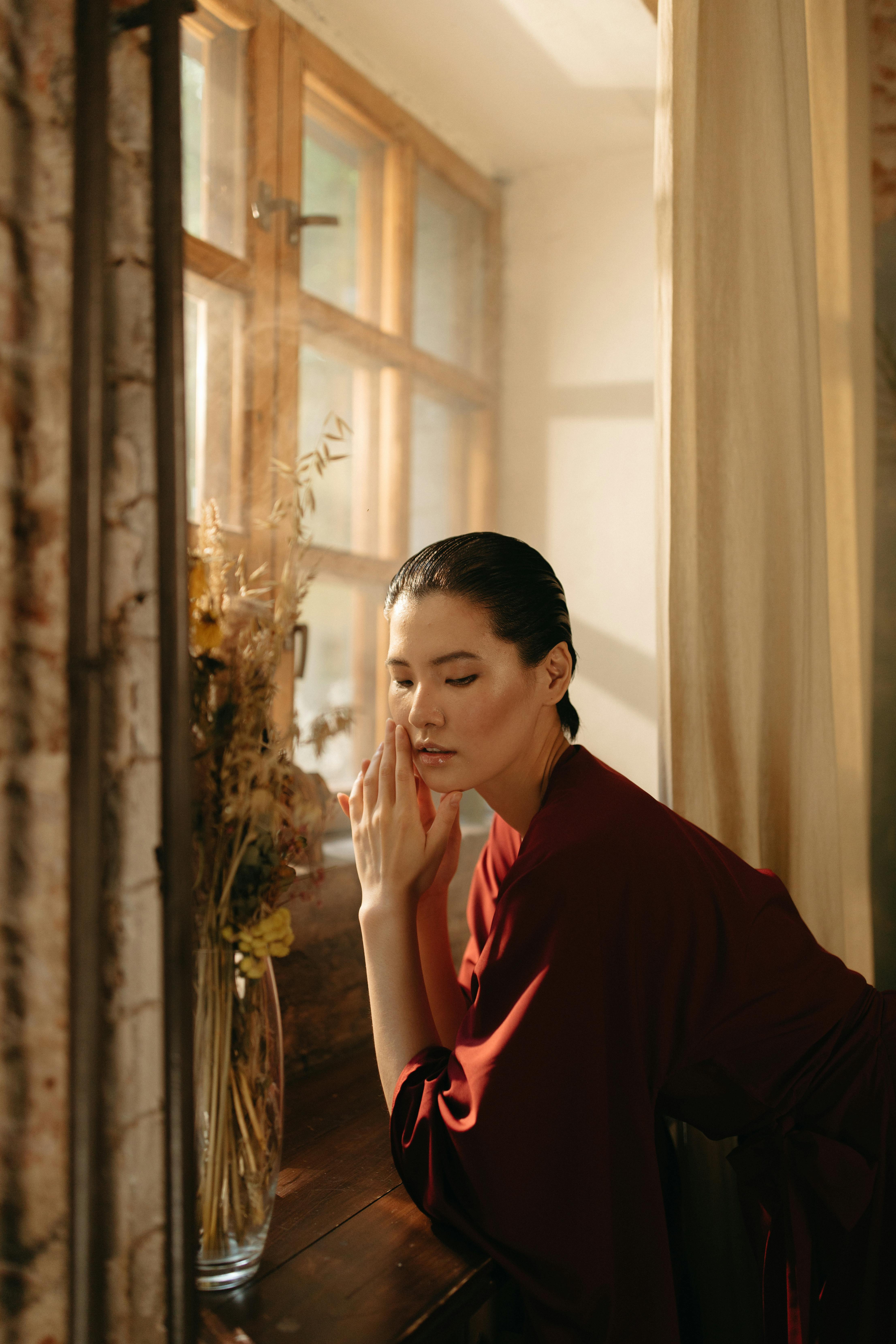 Woman in Red Robe Holding Curtain · Free Stock Photo