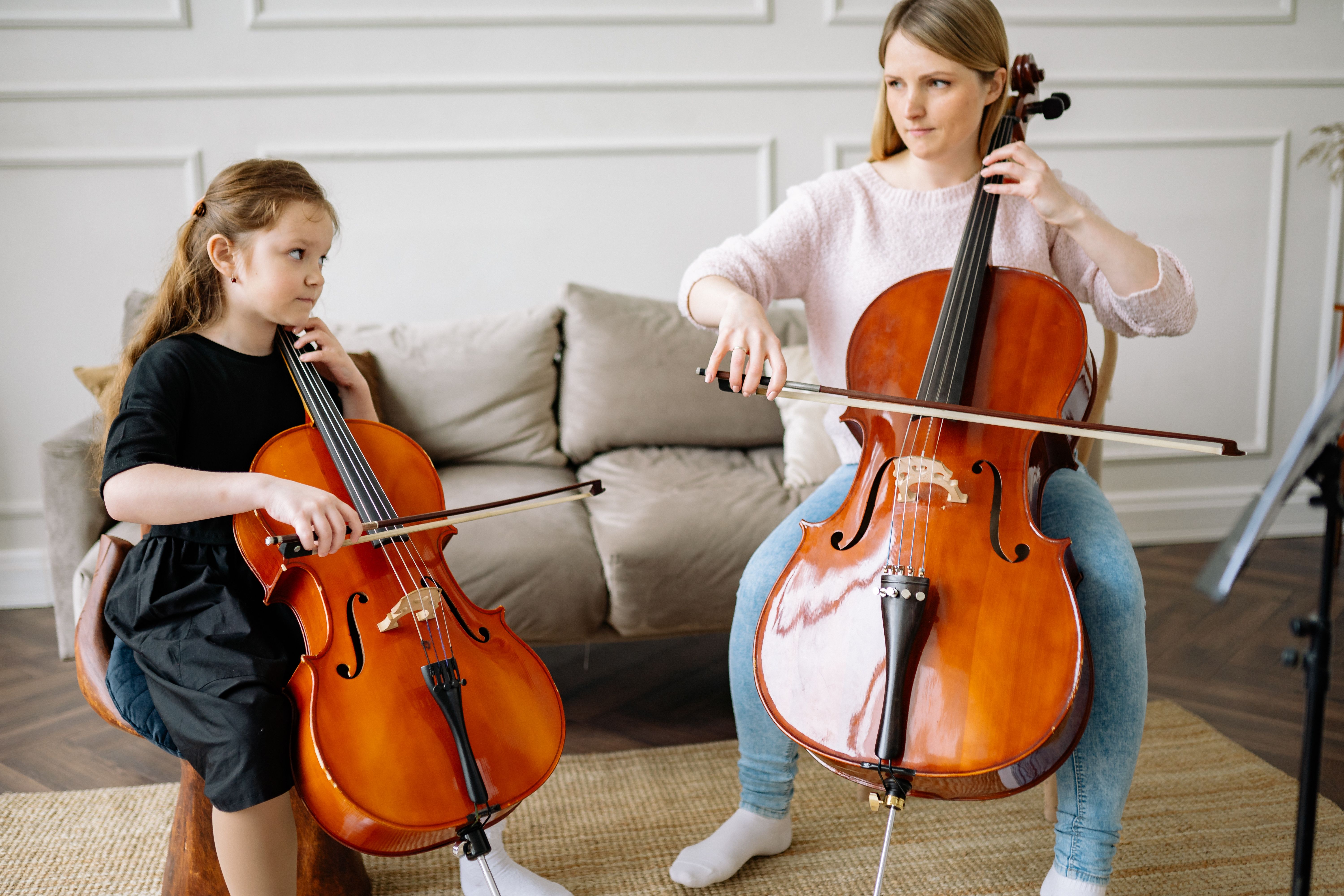 Young Girls Sitting while Playing Musical Instruments · Free Stock Photo
