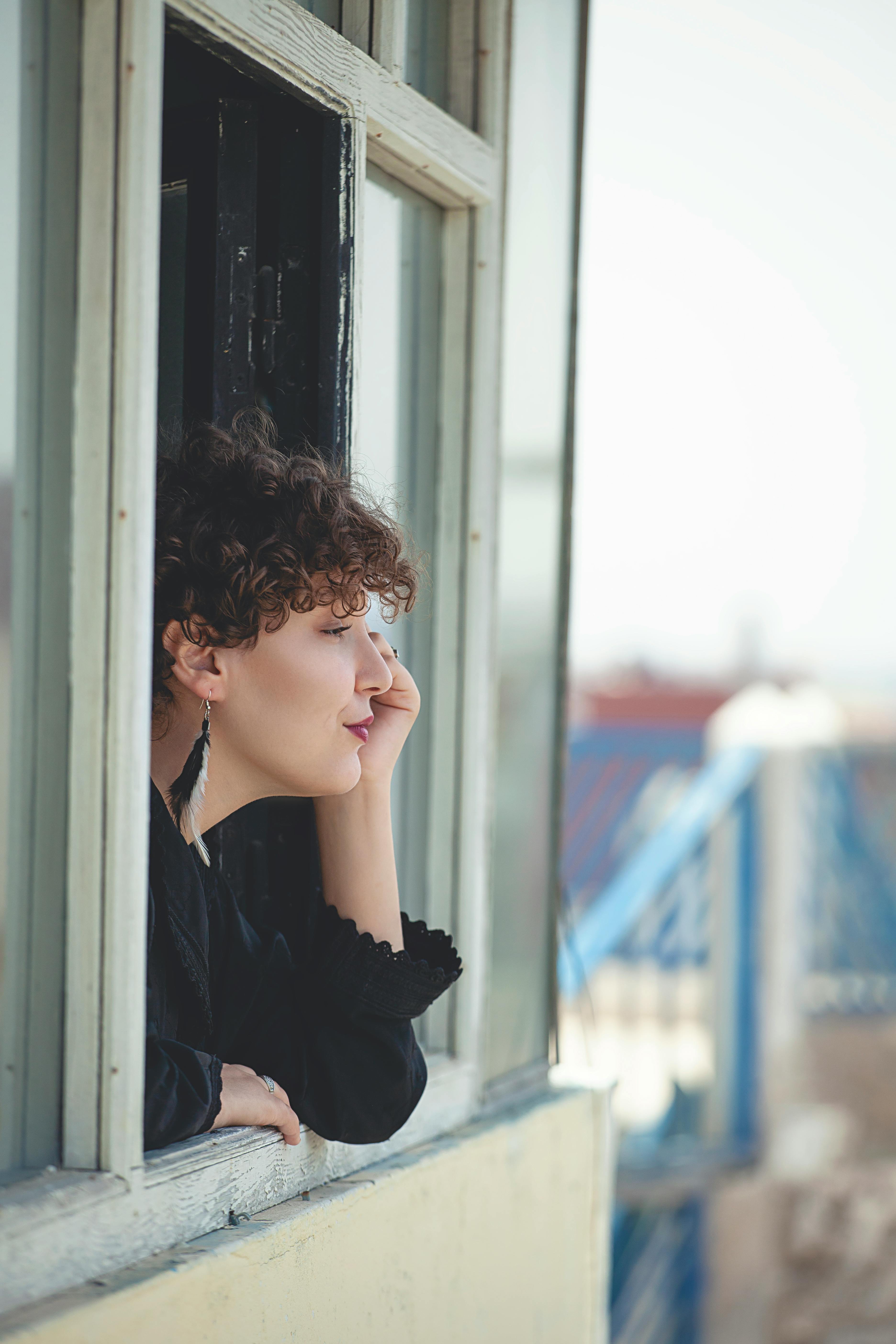 Woman Leaning on a Window · Free Stock Photo