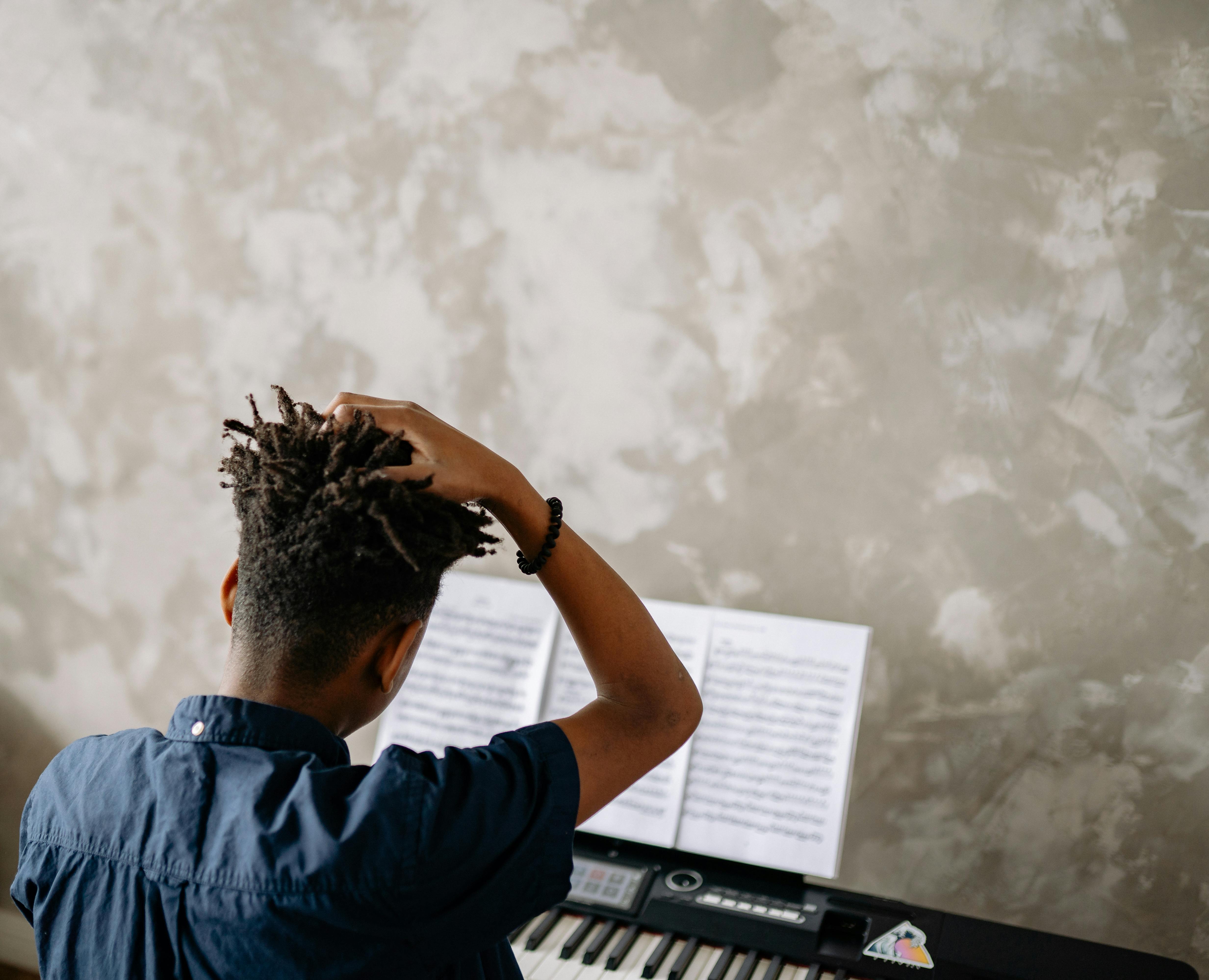 Boy Holding his Head while Playing the Piano · Free Stock Photo