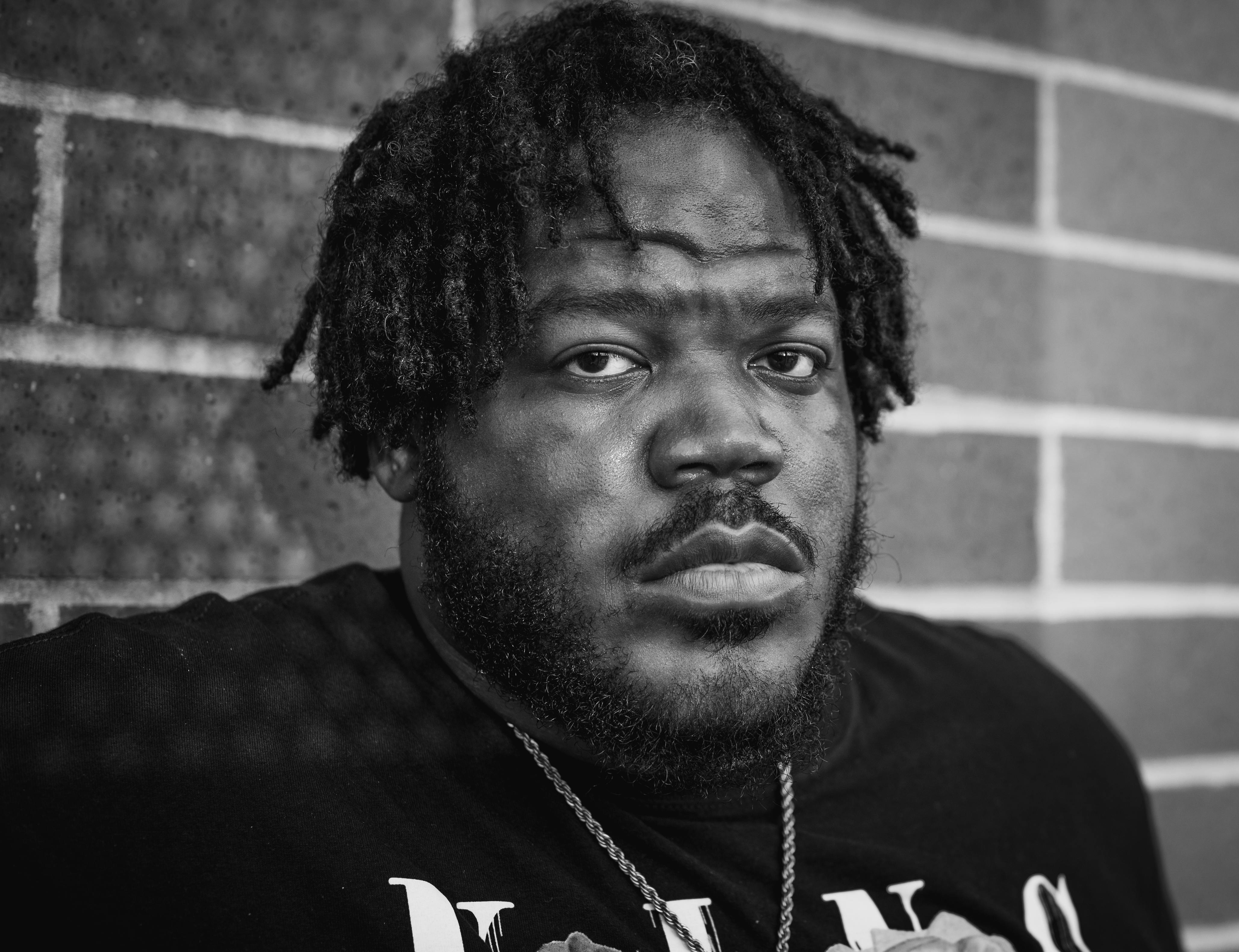 Grayscale Photo of Man Holding his Neck · Free Stock Photo