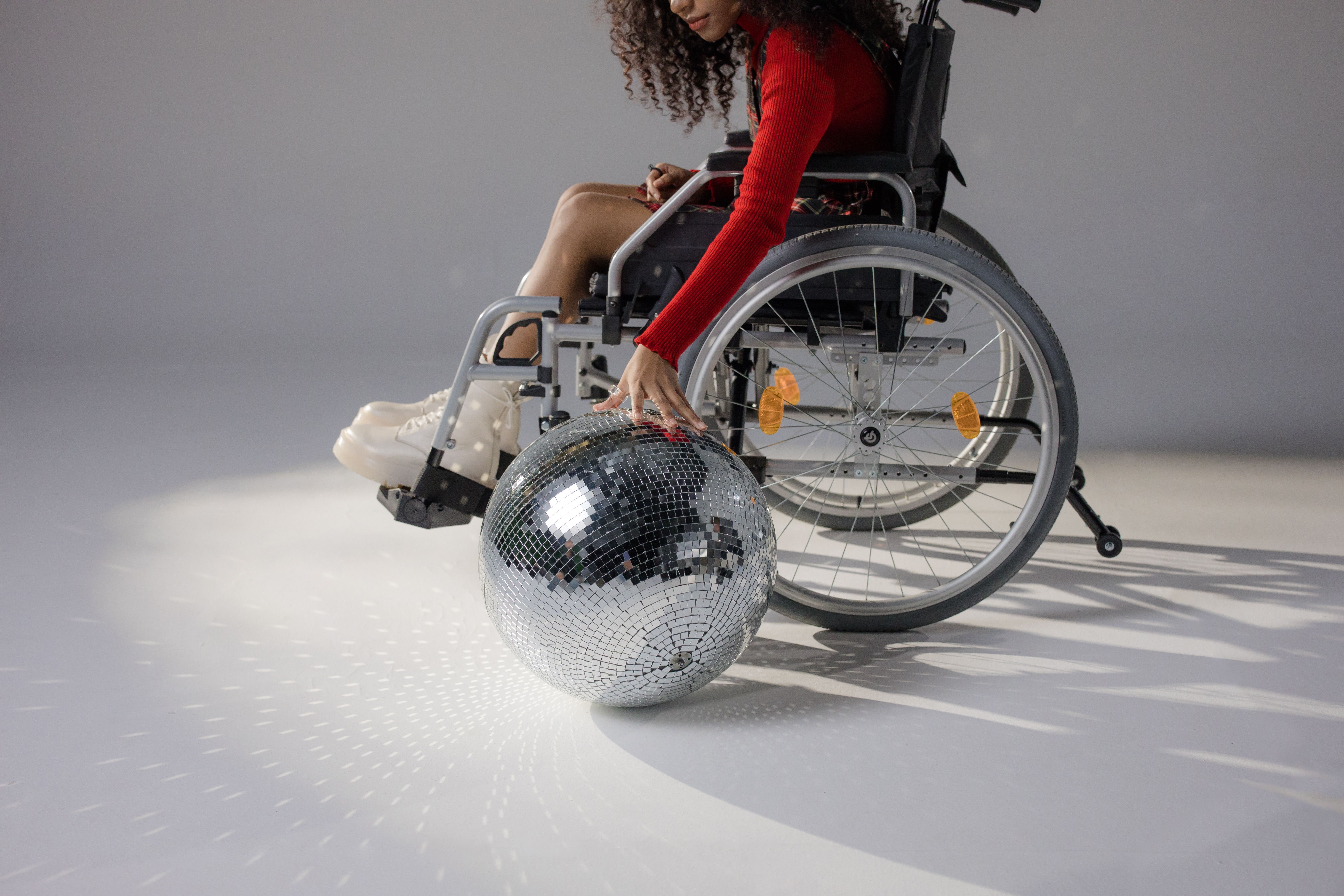 A Person in a Wheelchair Touching a Disco Ball on the Floor · Free ...