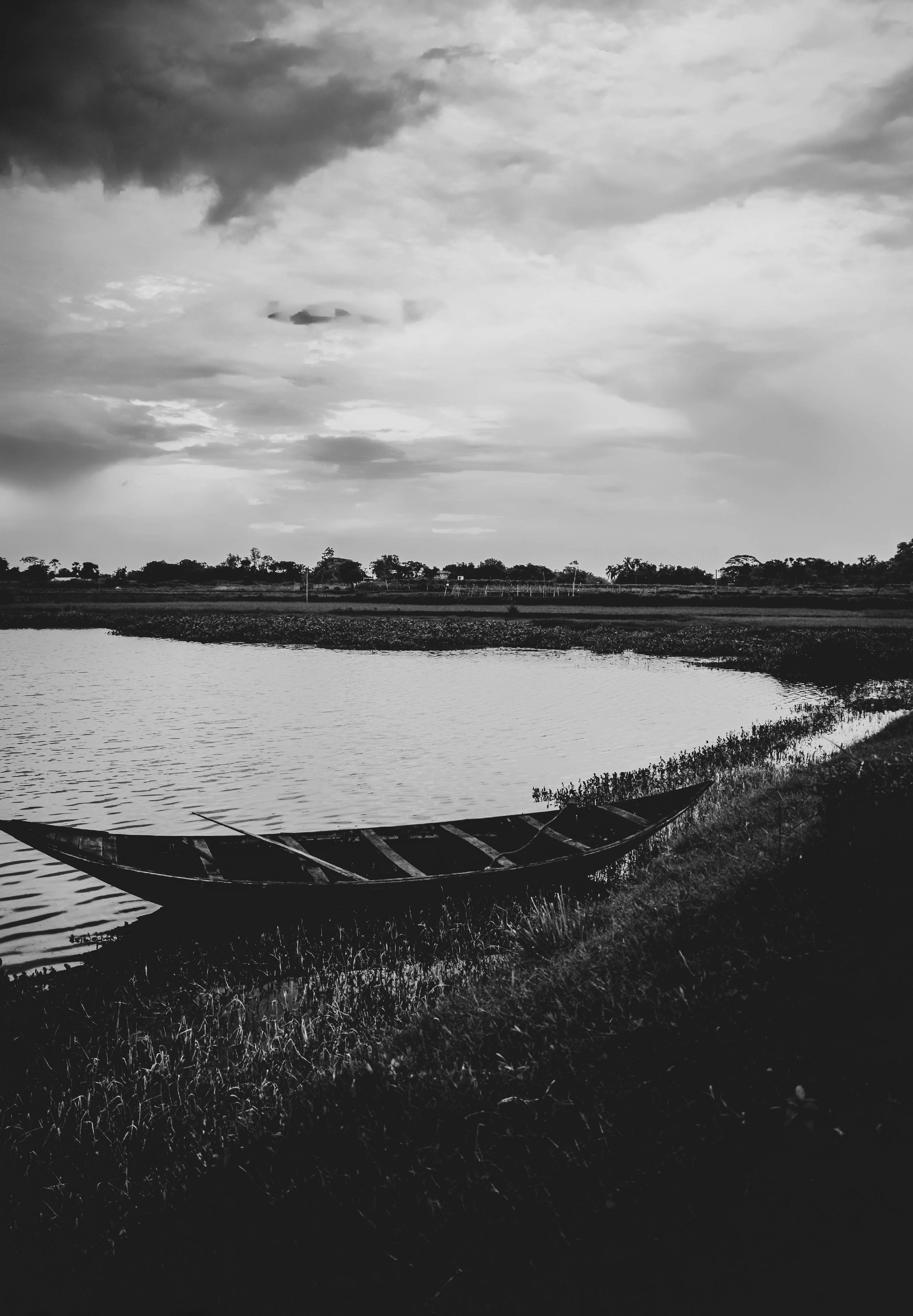 Grayscale Photo of a Wooden Boat near the Lake · Free Stock Photo
