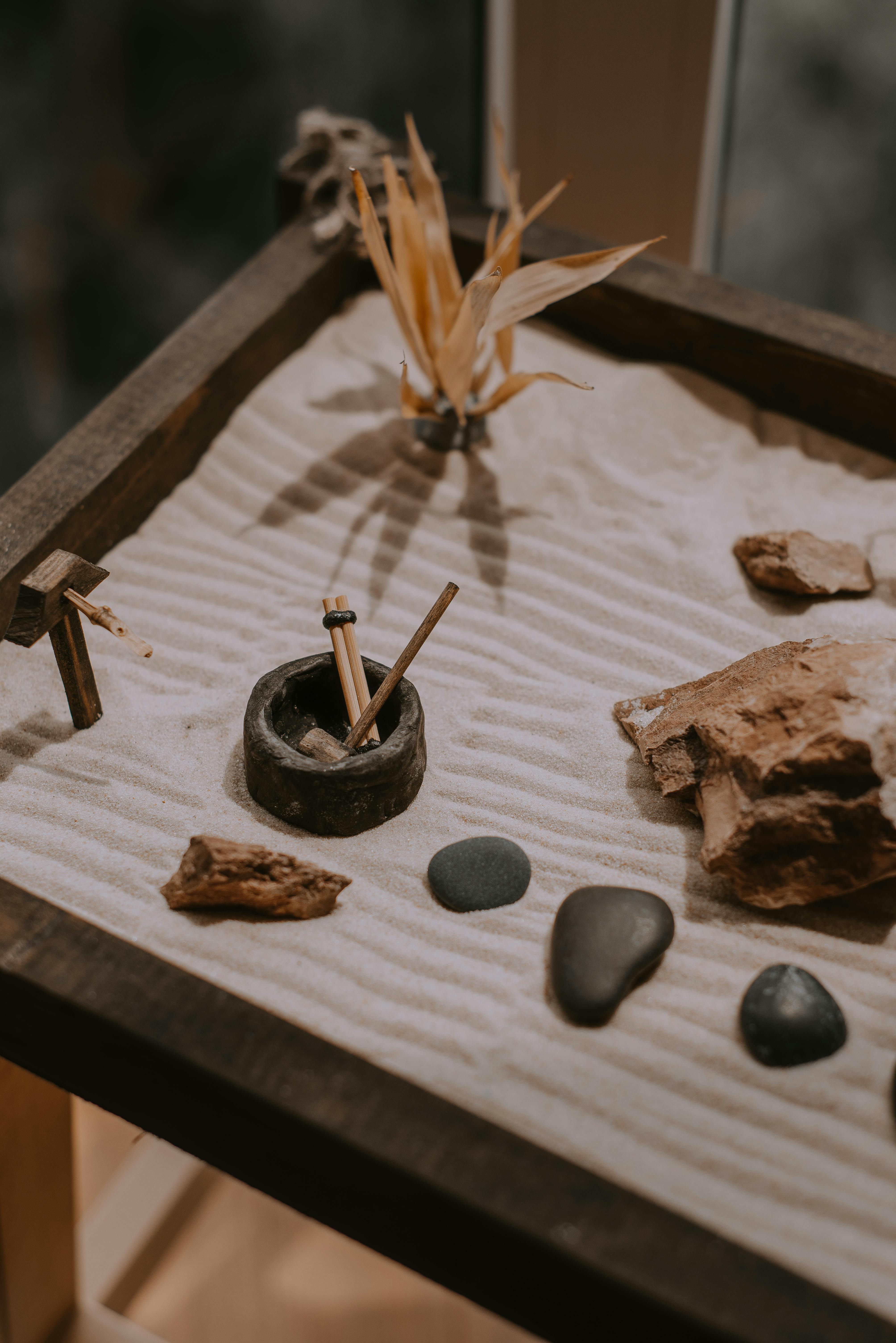 Brown Wooden Sticks and Pebbles in a Sandbox · Free Stock Photo