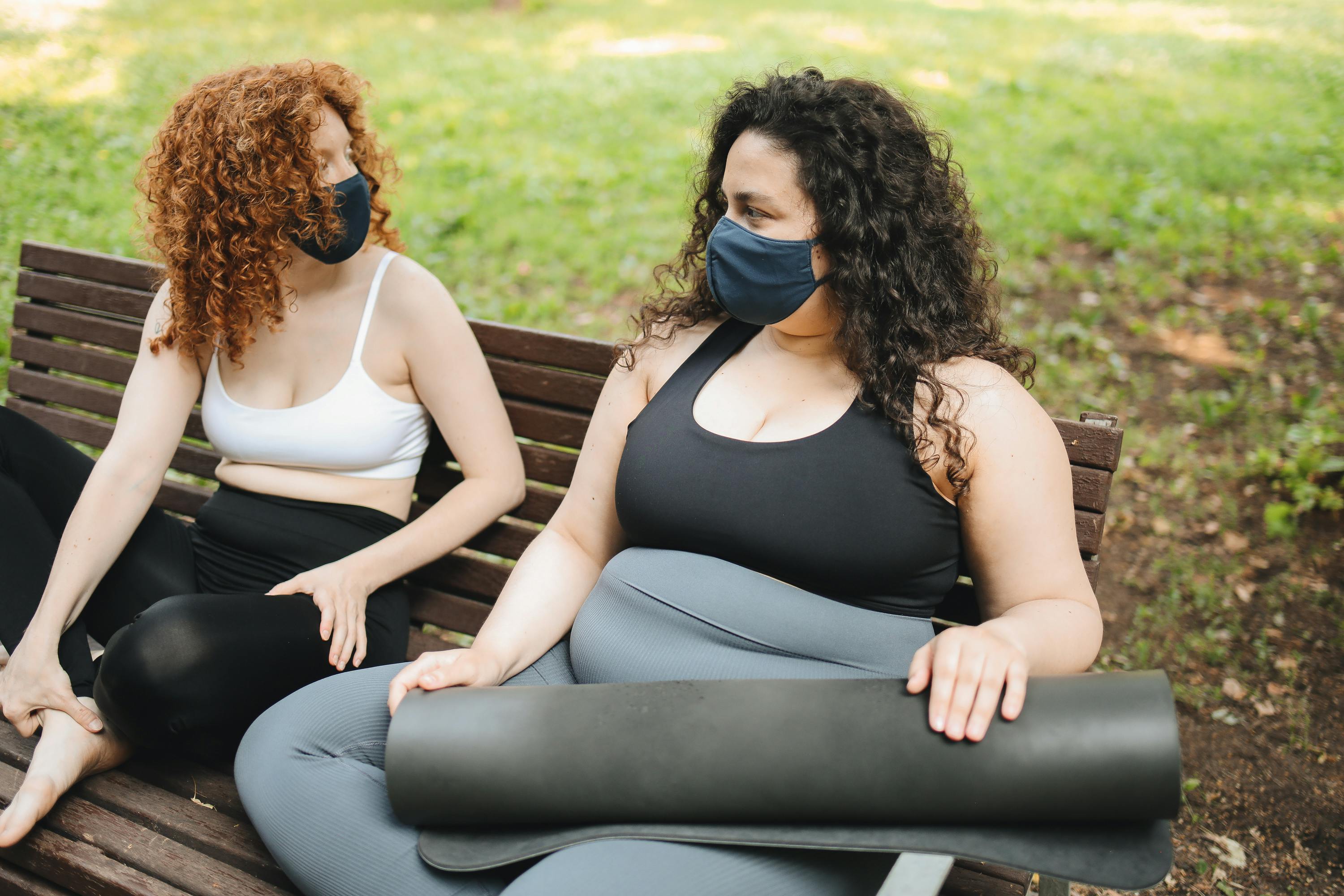 Women Wearing Face Masks Sitting on Wooden Bench · Free Stock Photo