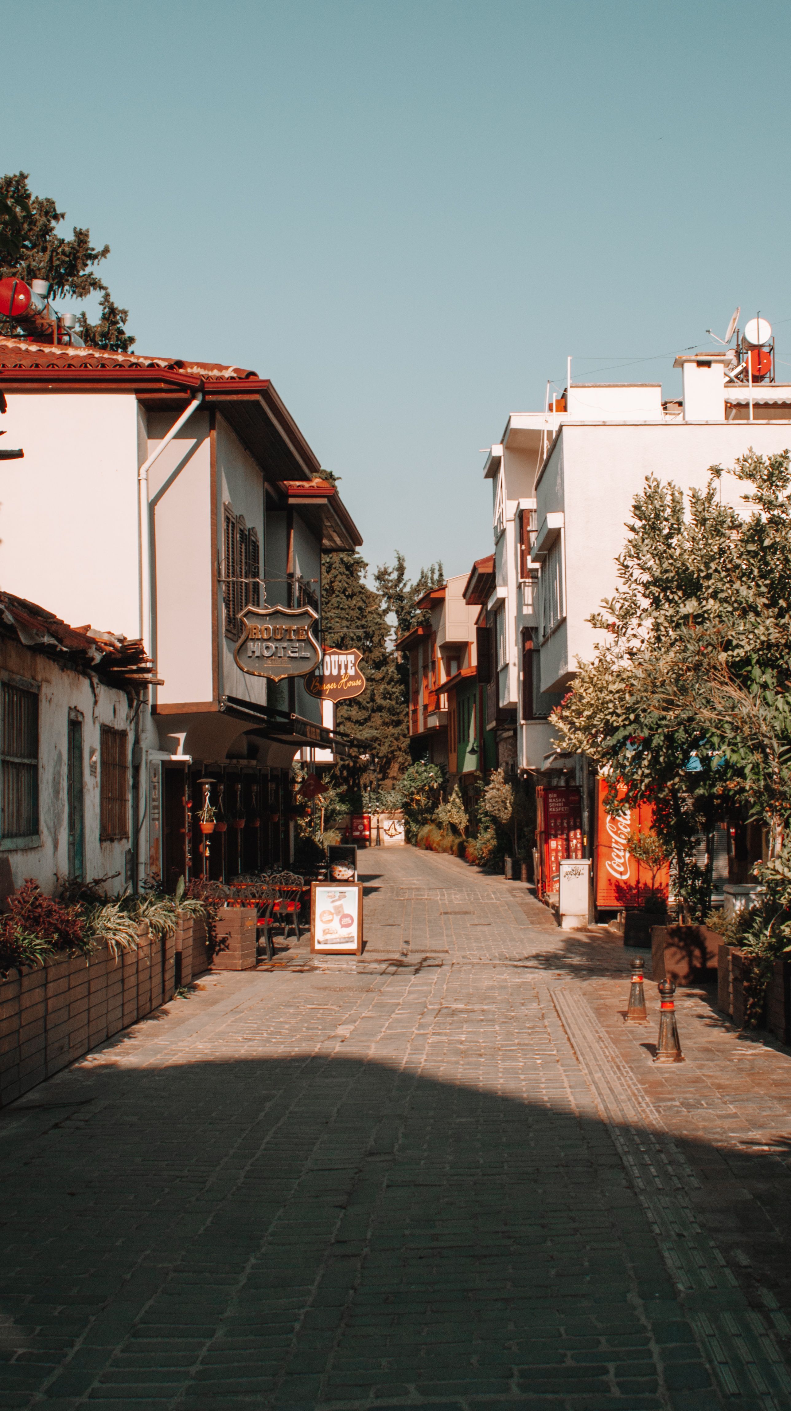 Stone Paved Alley in between Brown Concrete Buildings · Free Stock Photo