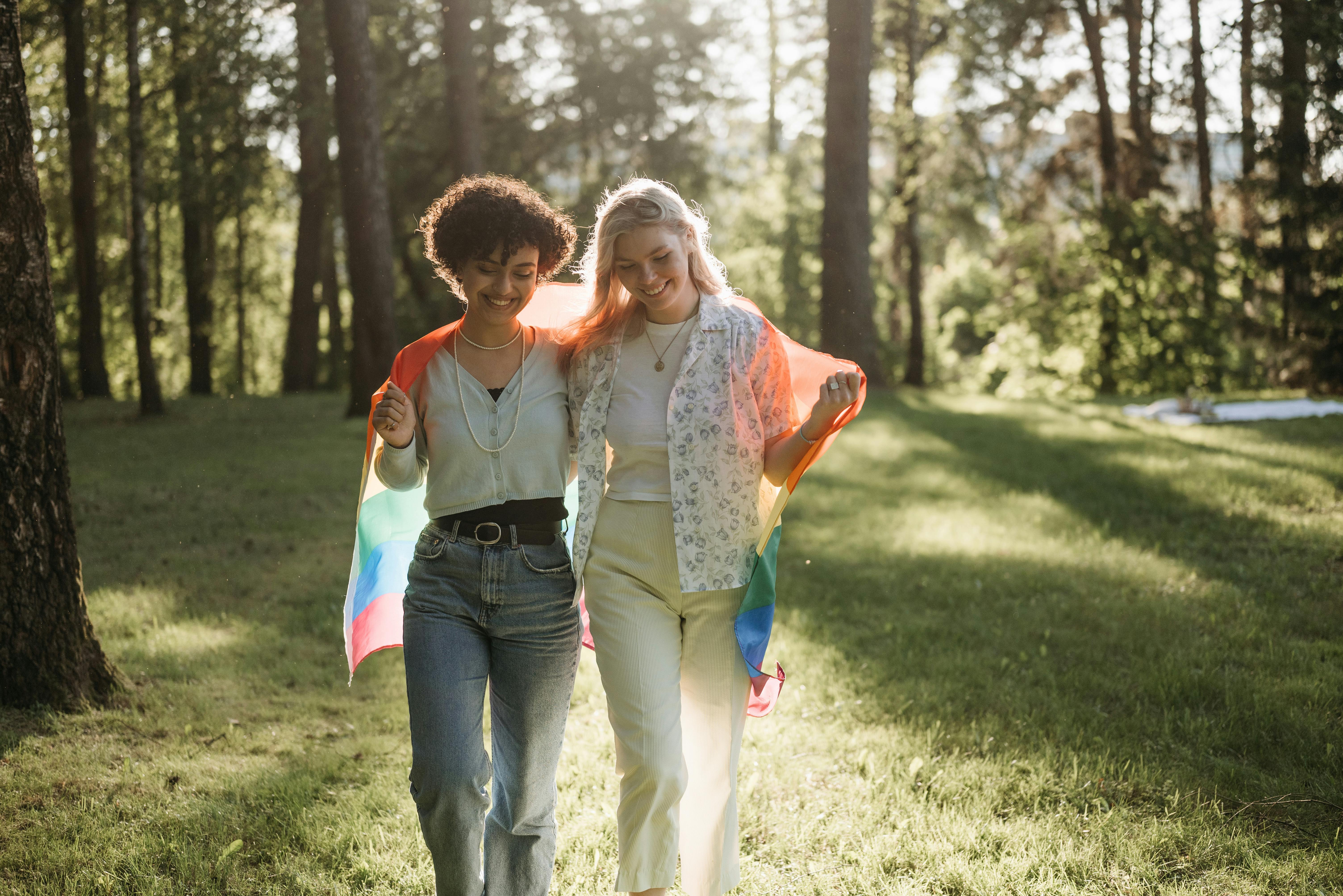 A Happy Couple Wrapped in a Rainbow Flag · Free Stock Photo