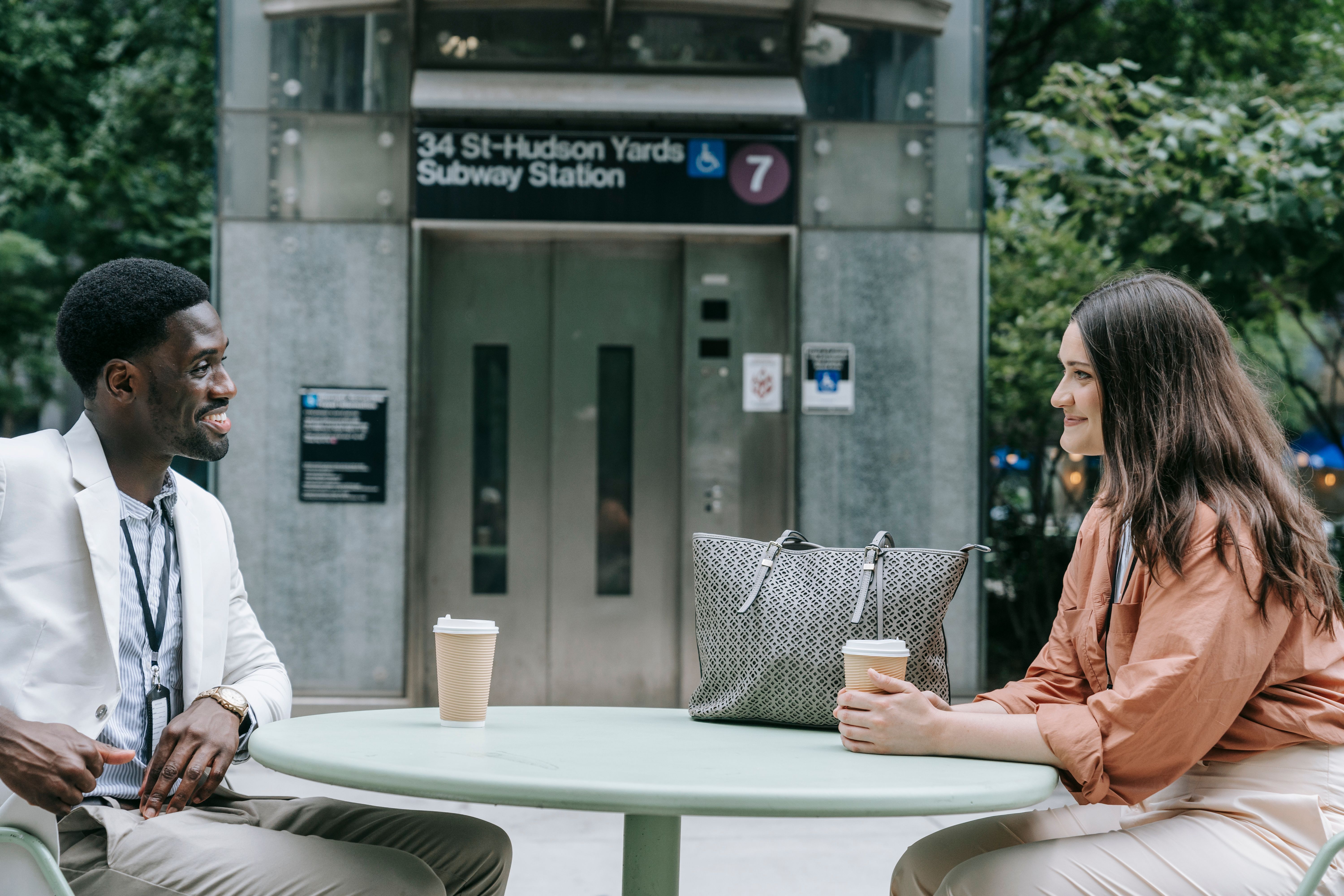 Woman and Man Sitting near Elevator to Metro Station · Free Stock Photo