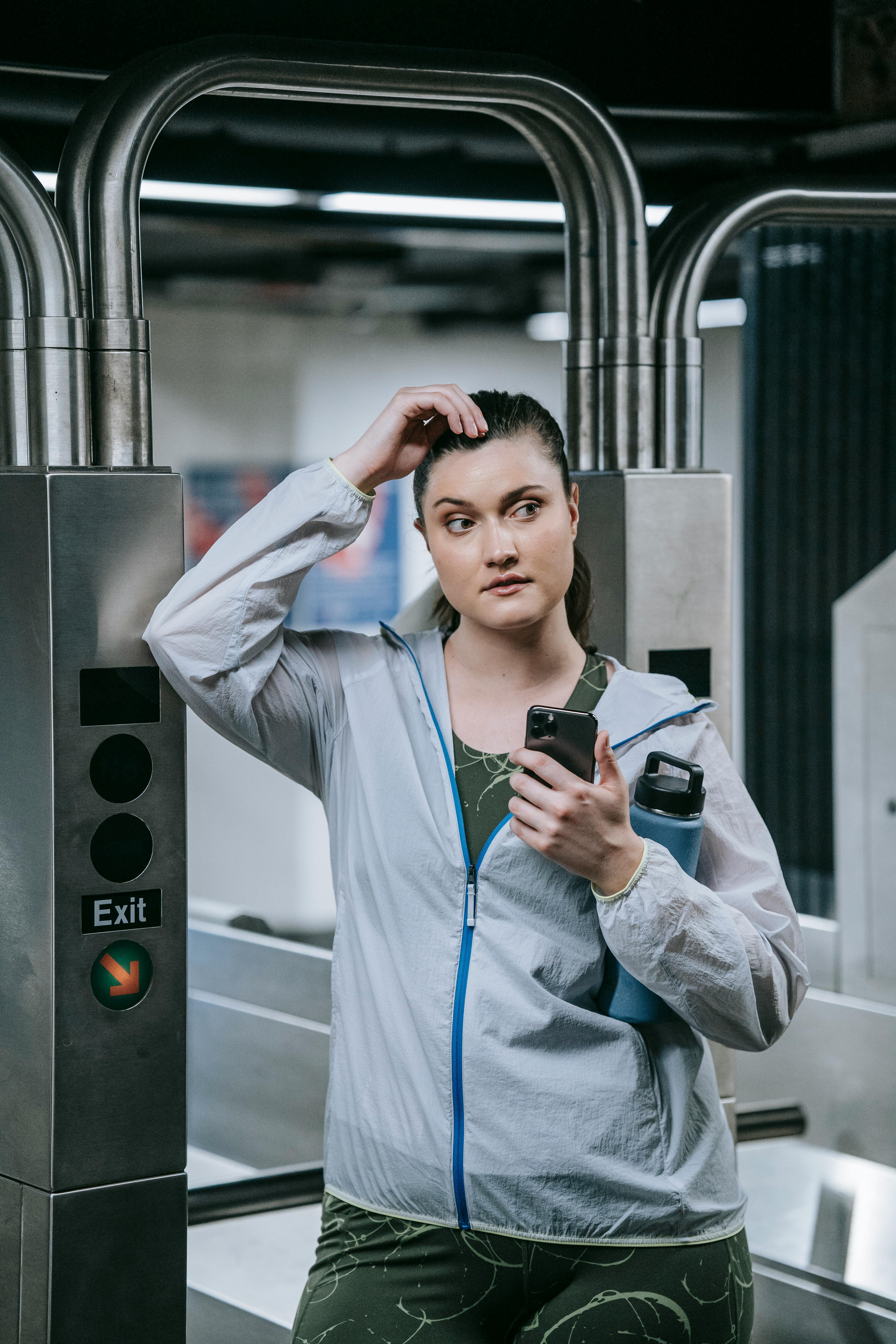 A Woman Posing While Holding Smartphone · Free Stock Photo
