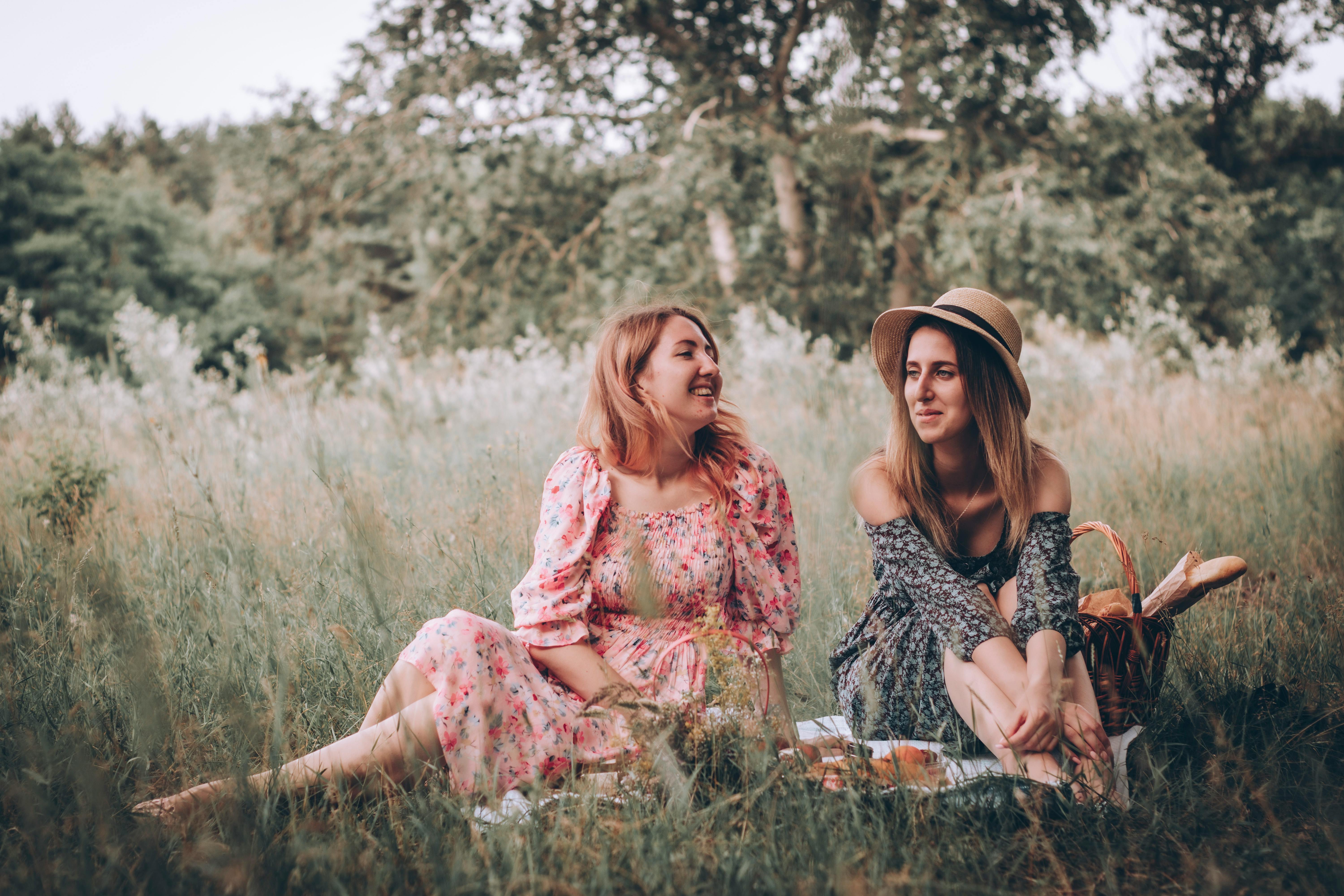 2 Women Sitting on Grass Field on Picnic · Free Stock Photo