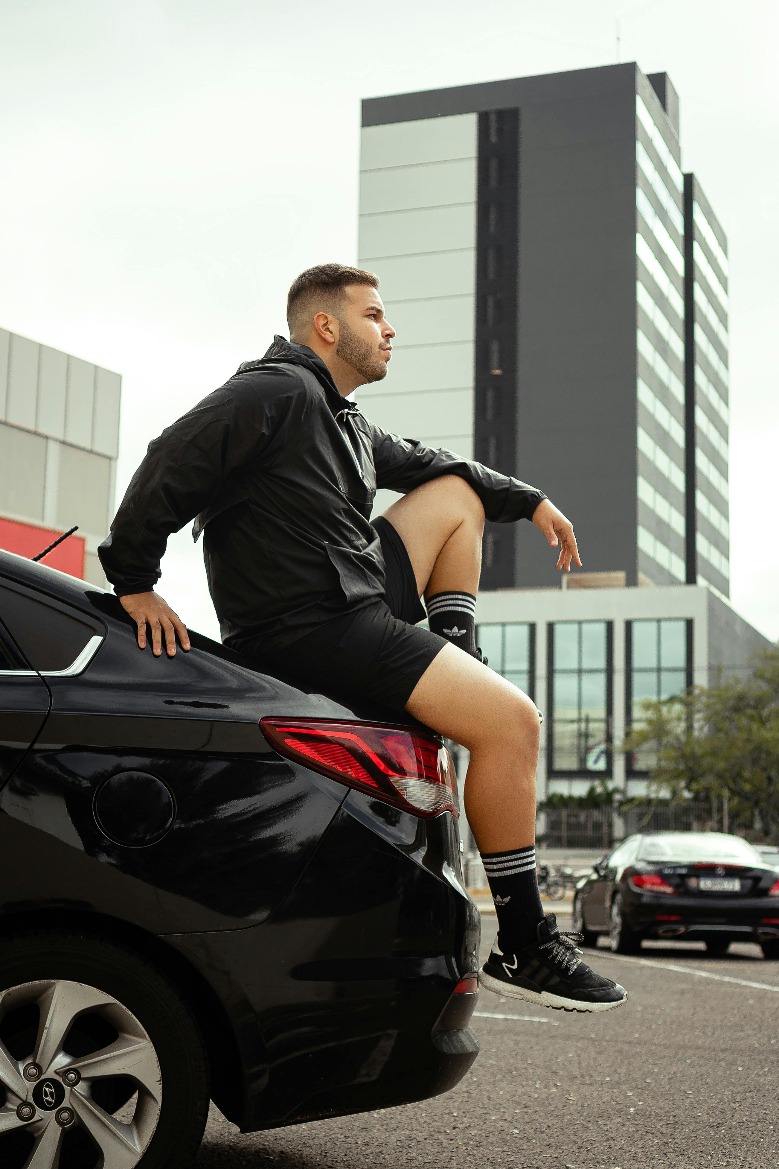 Man Sitting on Black Car · Free Stock Photo