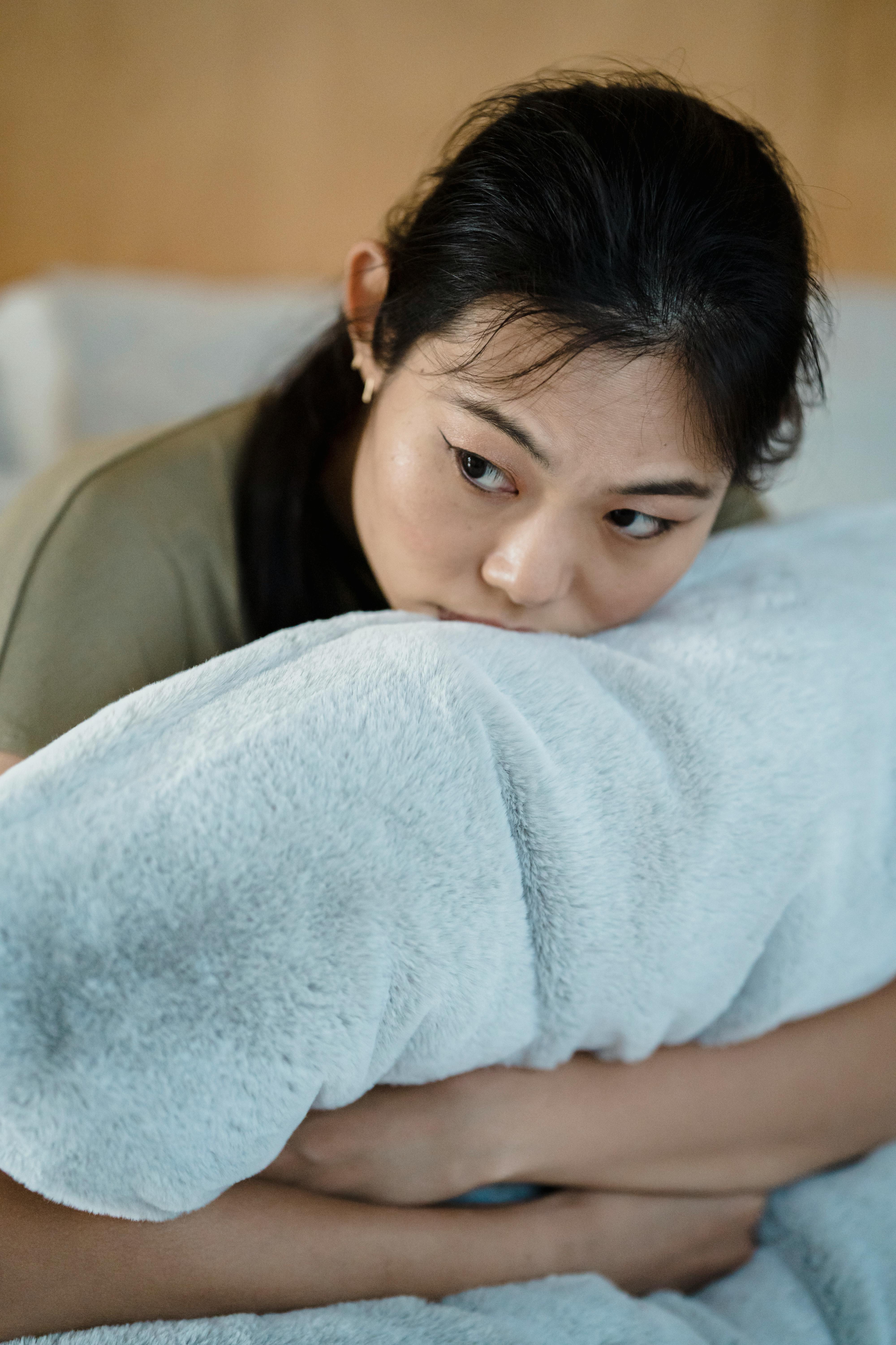 Portrait of a Young Woman Hugging a Pillow · Free Stock Photo