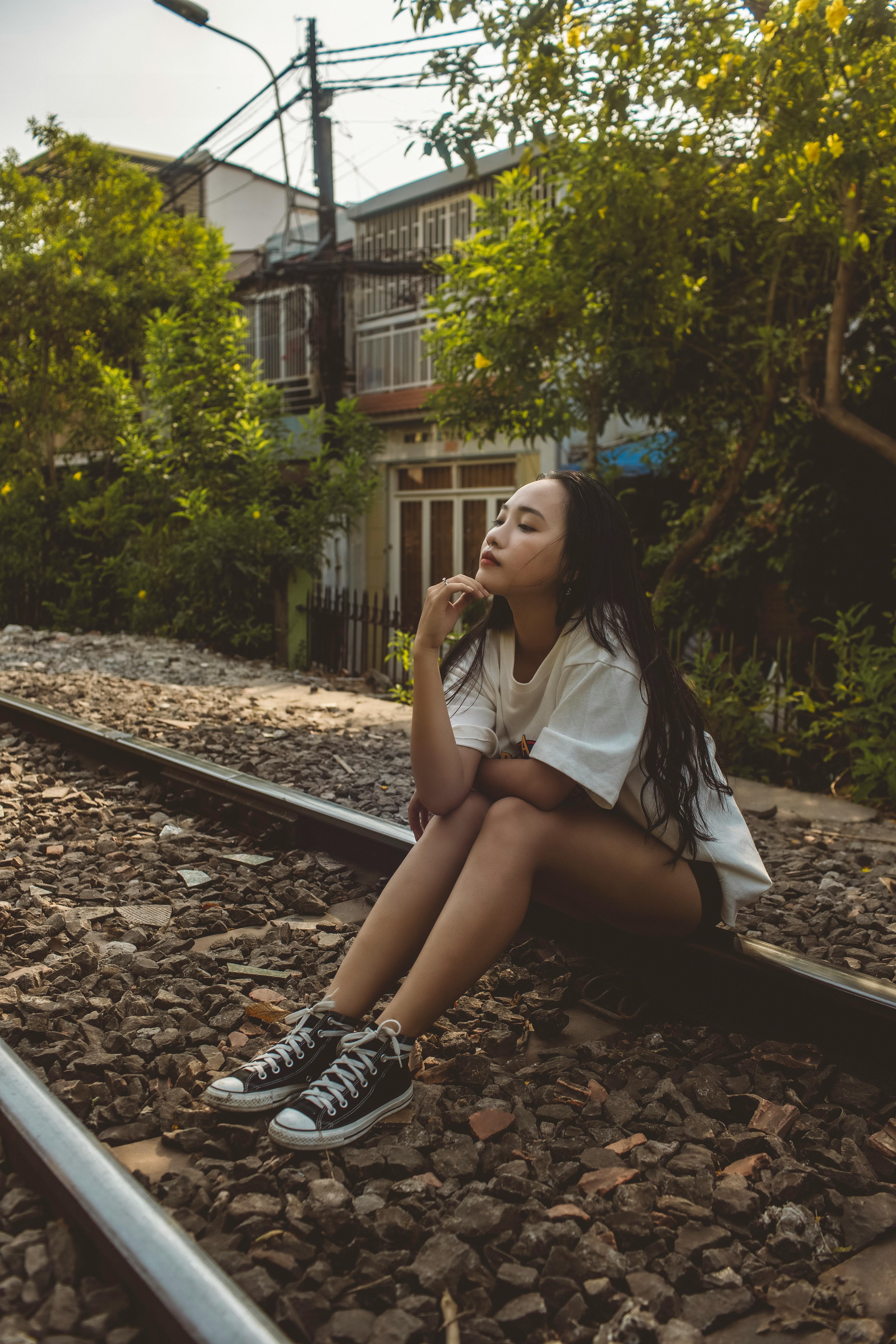Woman Sitting on Train Tracks · Free Stock Photo